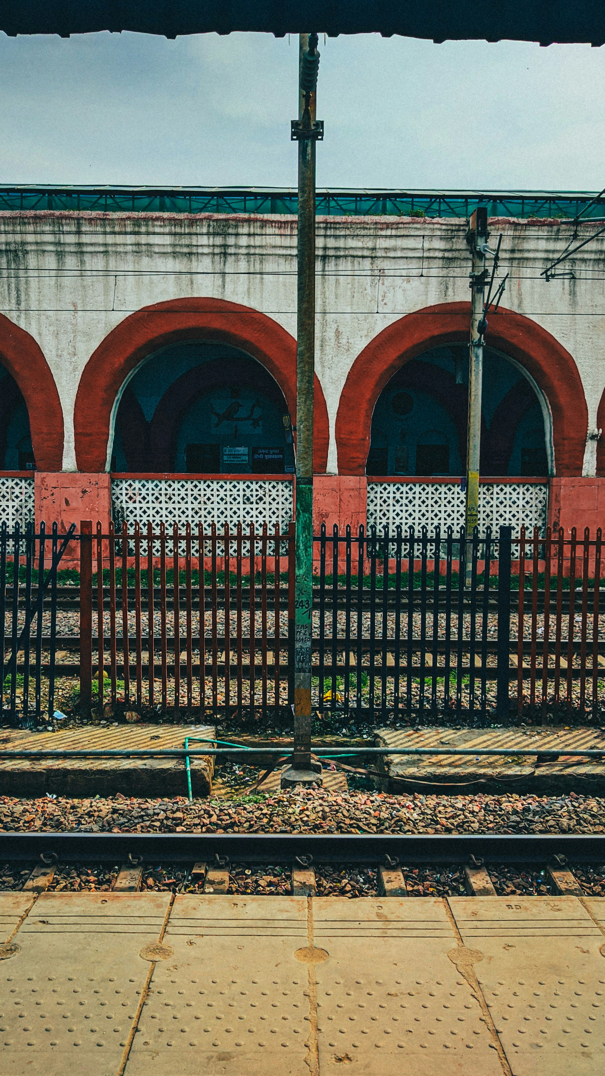 Pole of Silence: Symmetry and Rails at a Red-Arched Station