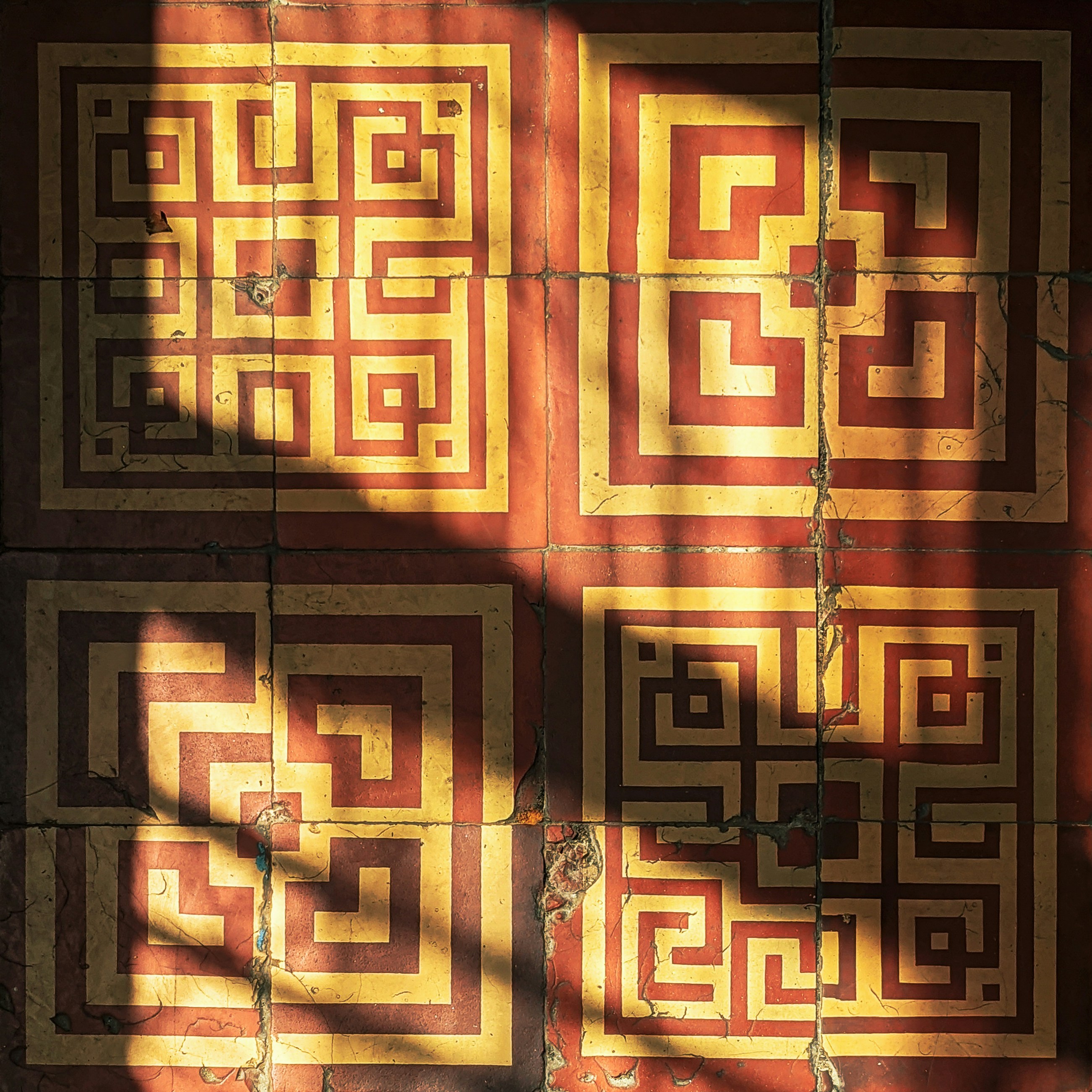 Geometric gold on terracotta: a tiled grid of nested squares