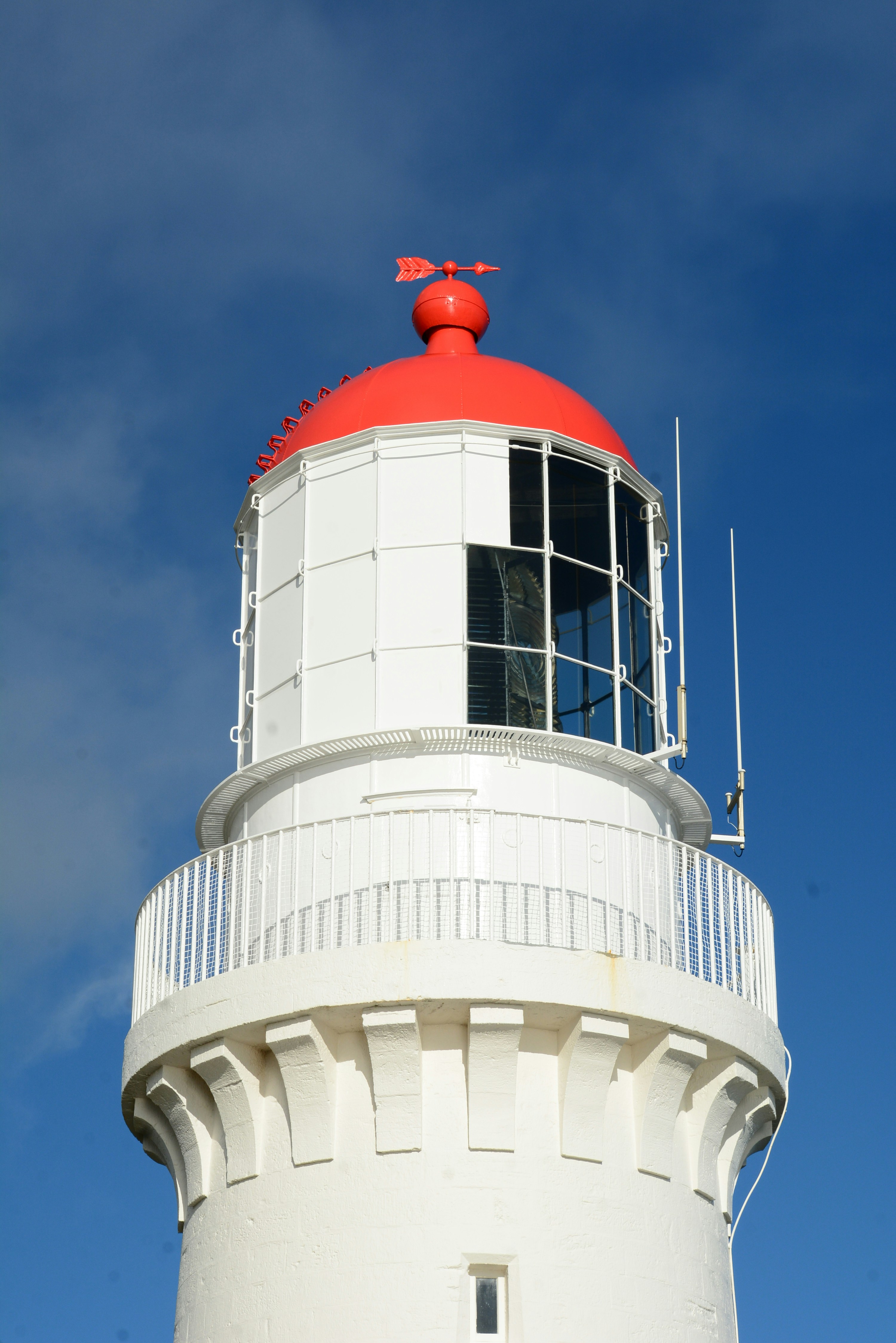 Crimson Crown of the Lighthouse Against a Royal Blue Sky