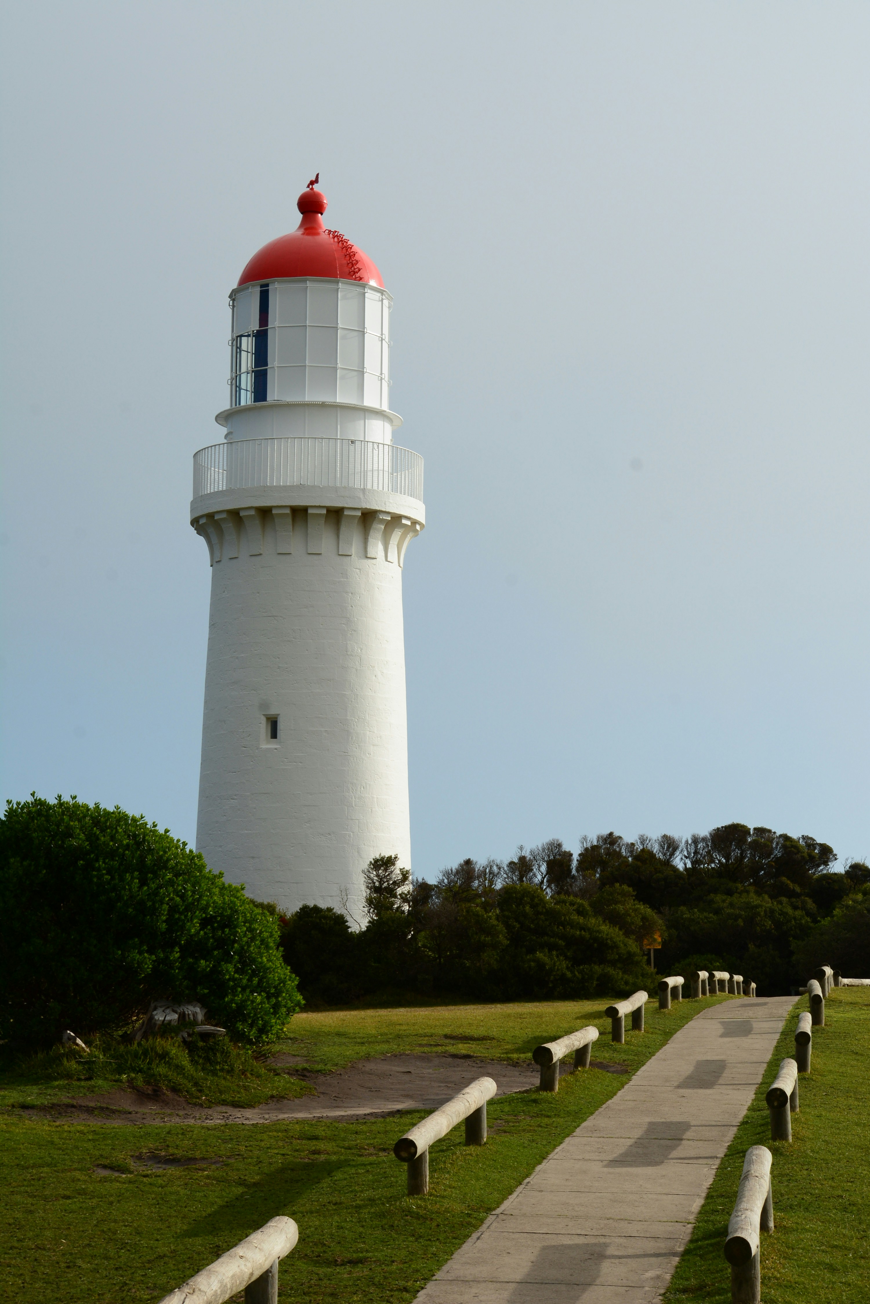 a white lighthouse with a red top