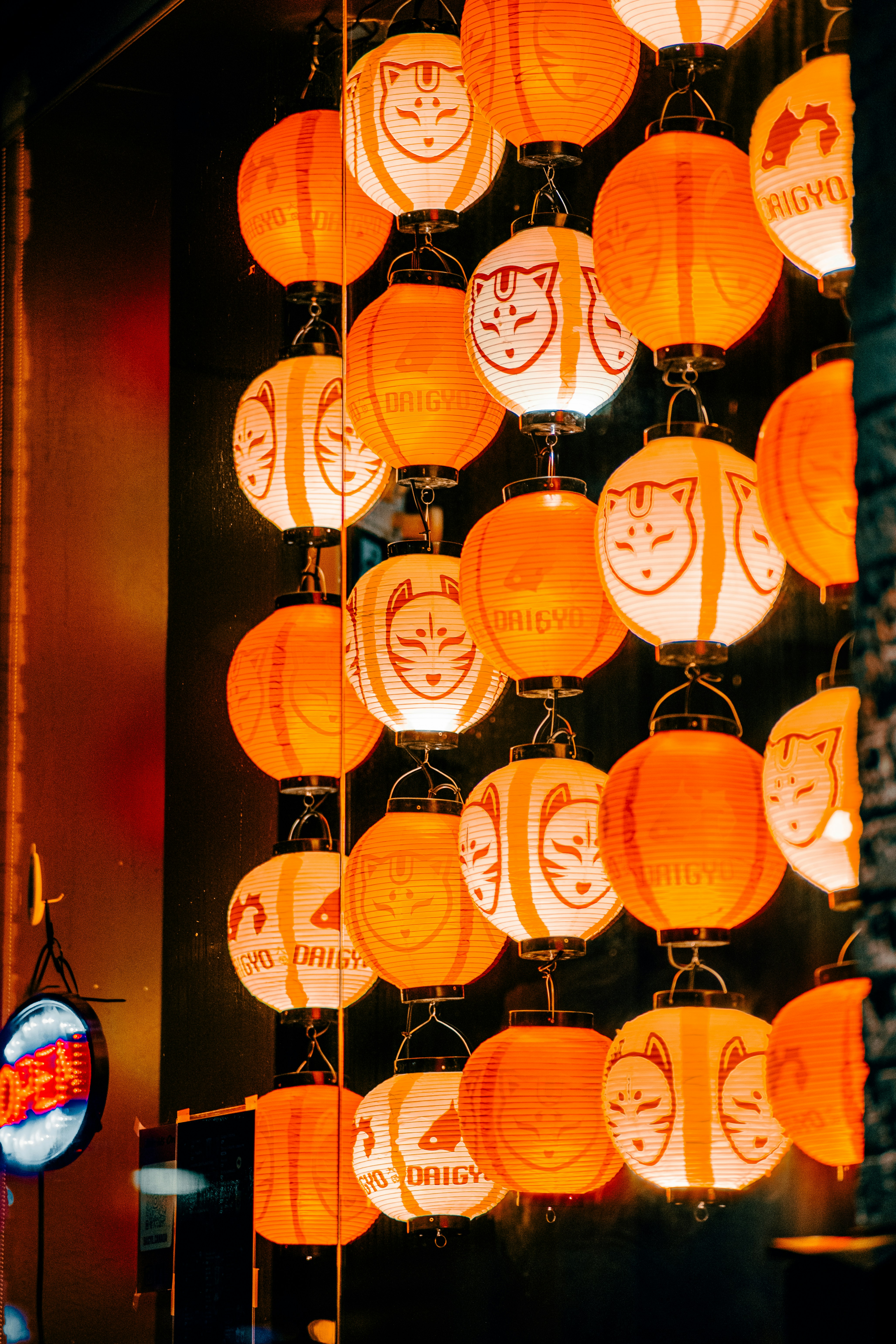 Cascade of Warm Orange Orbs in a Neon Lantern Window