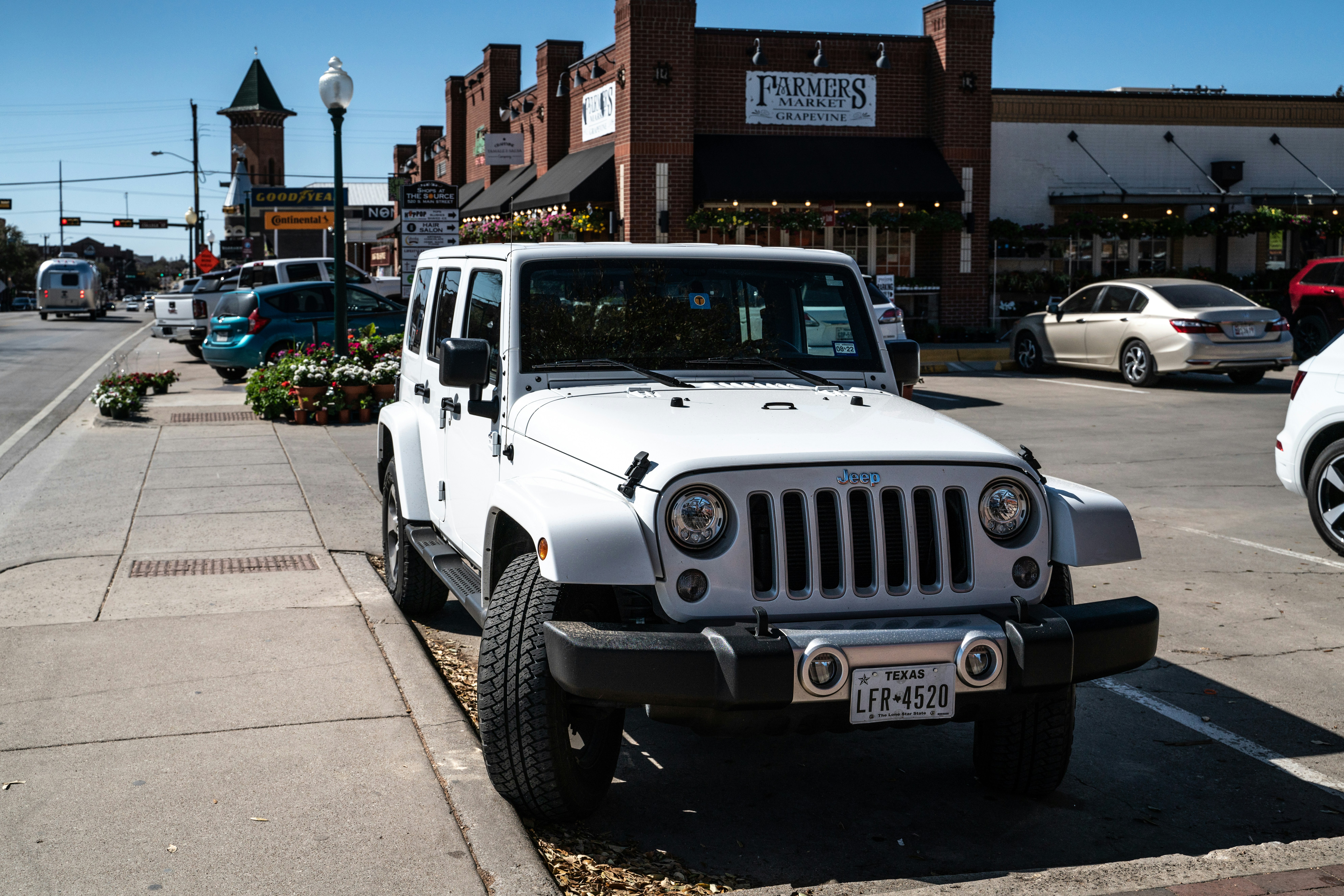 White Jeep Wrangler Anchors a Sunlit Main Street