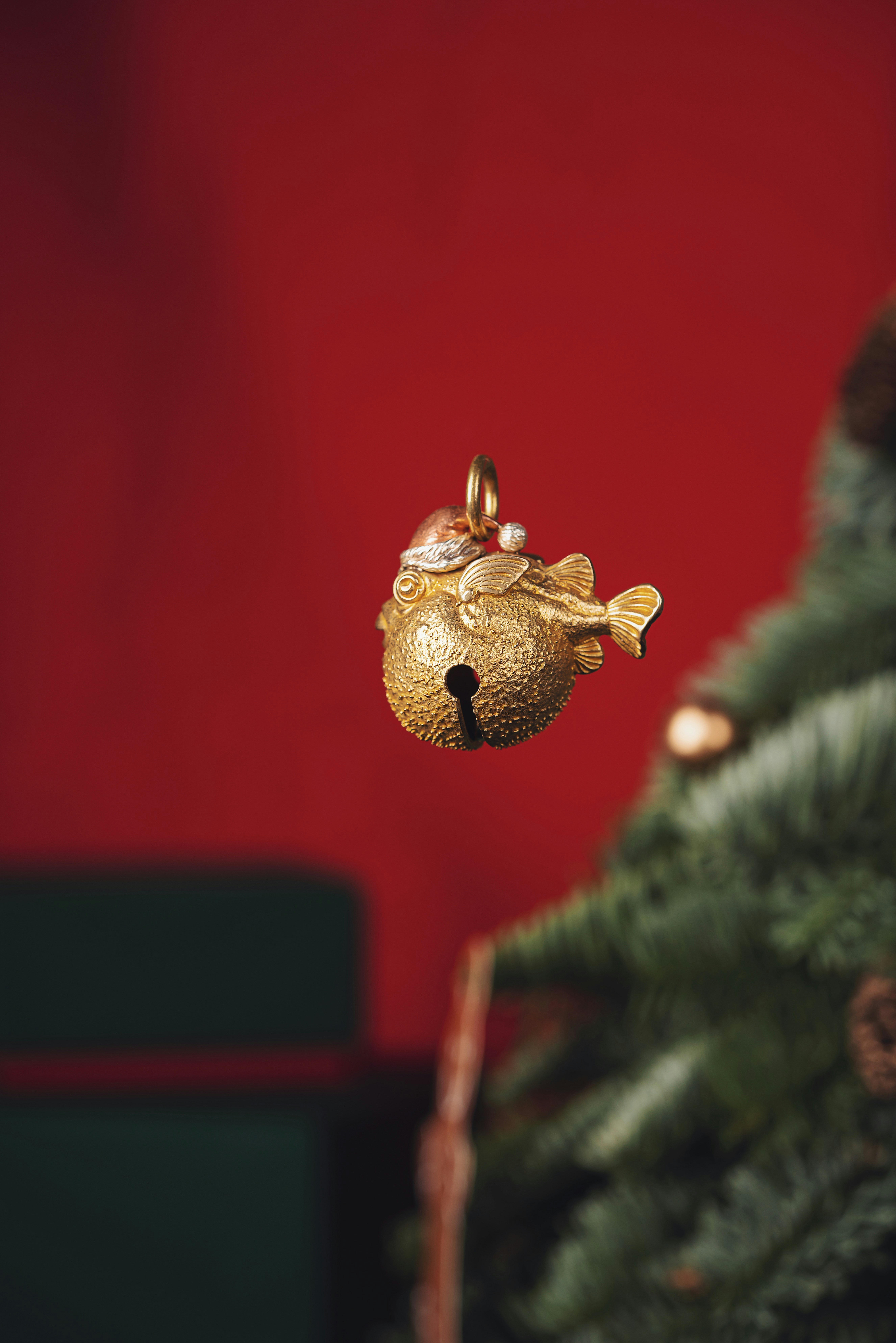 Floating Golden Fish Ornament in a Crimson Holiday Backdrop
