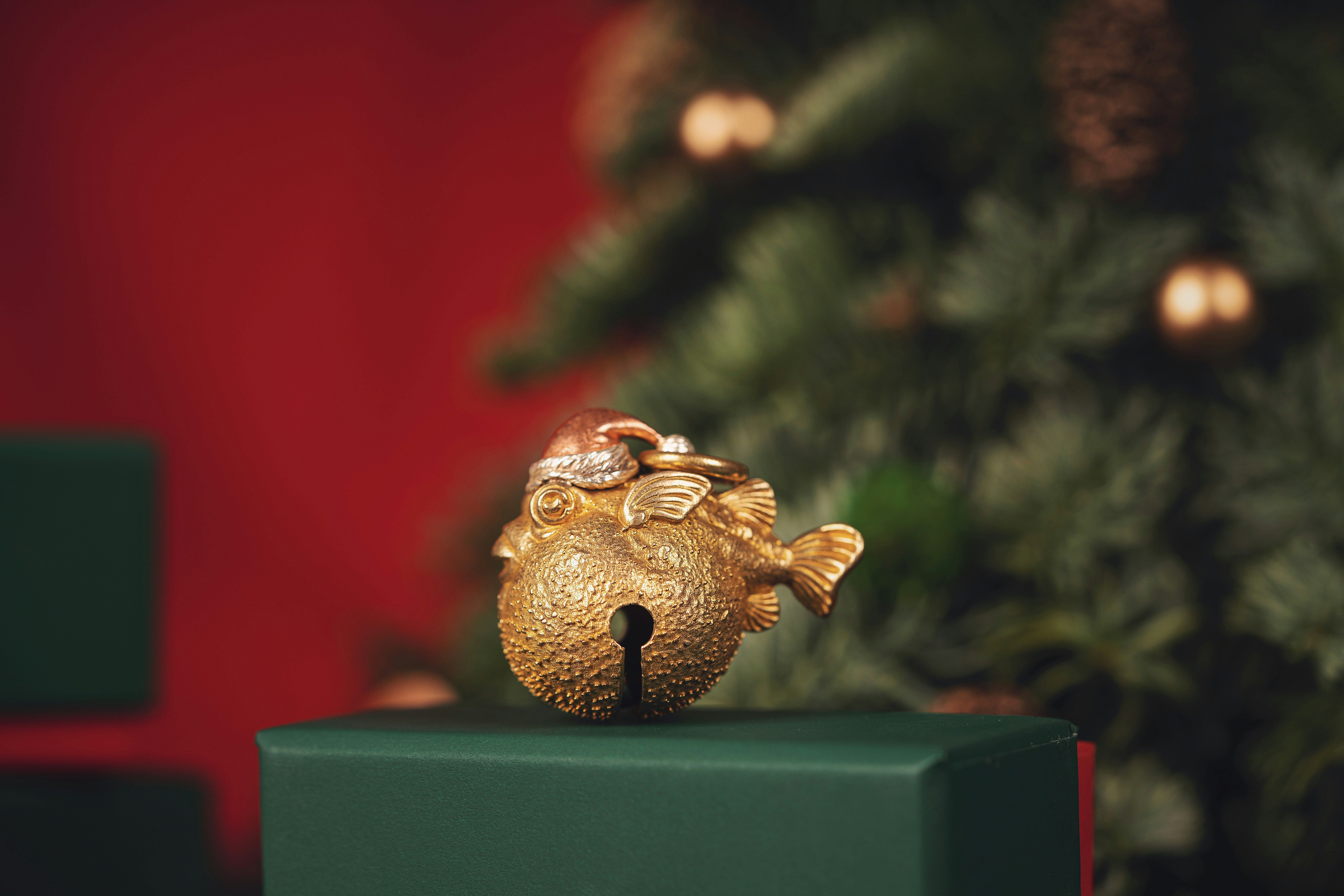 Gold Bell on a Forest-Green Gift Under Soft Holiday Glow