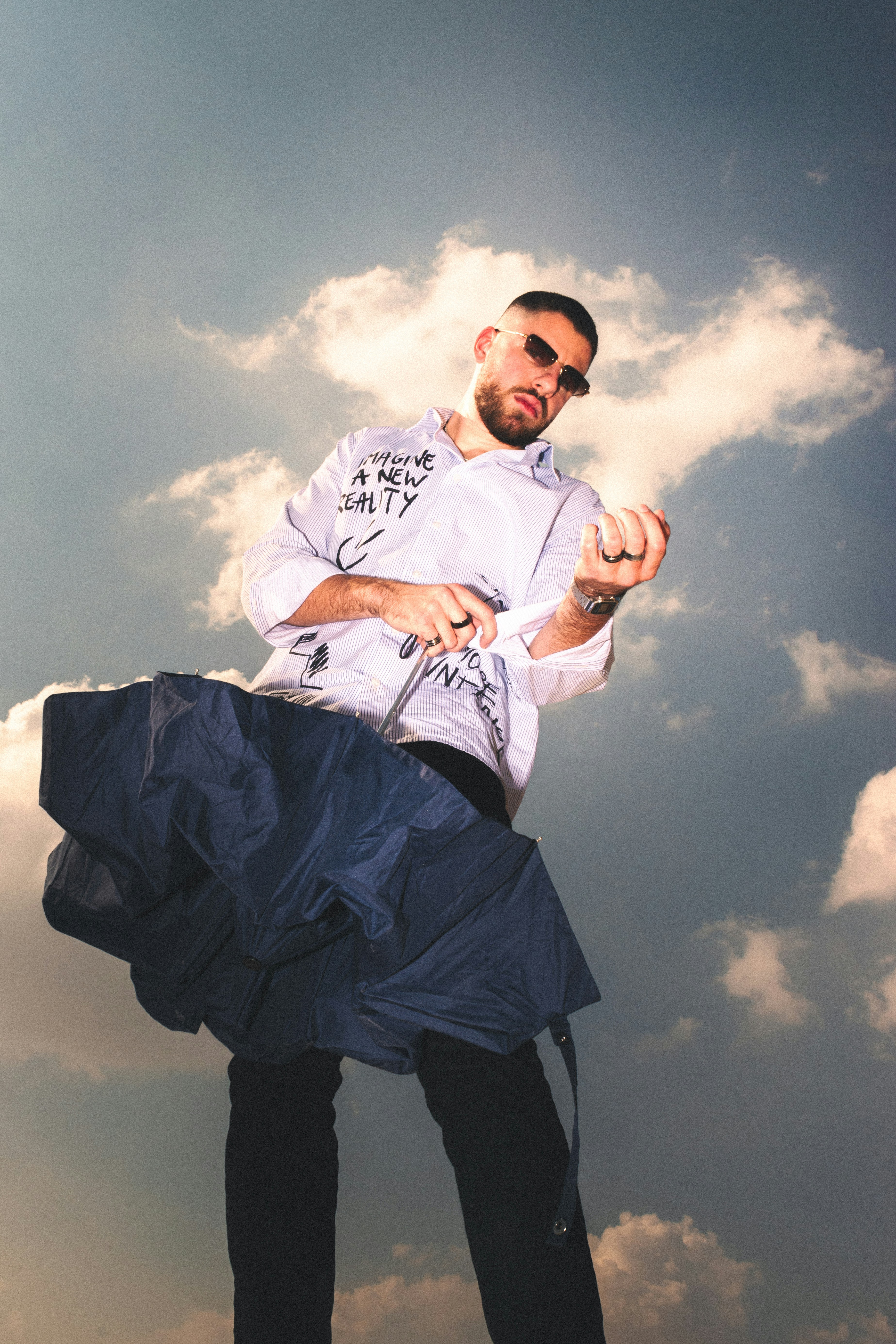 Edge of the Sky: A Low-Angle Portrait with a Billowing Coat