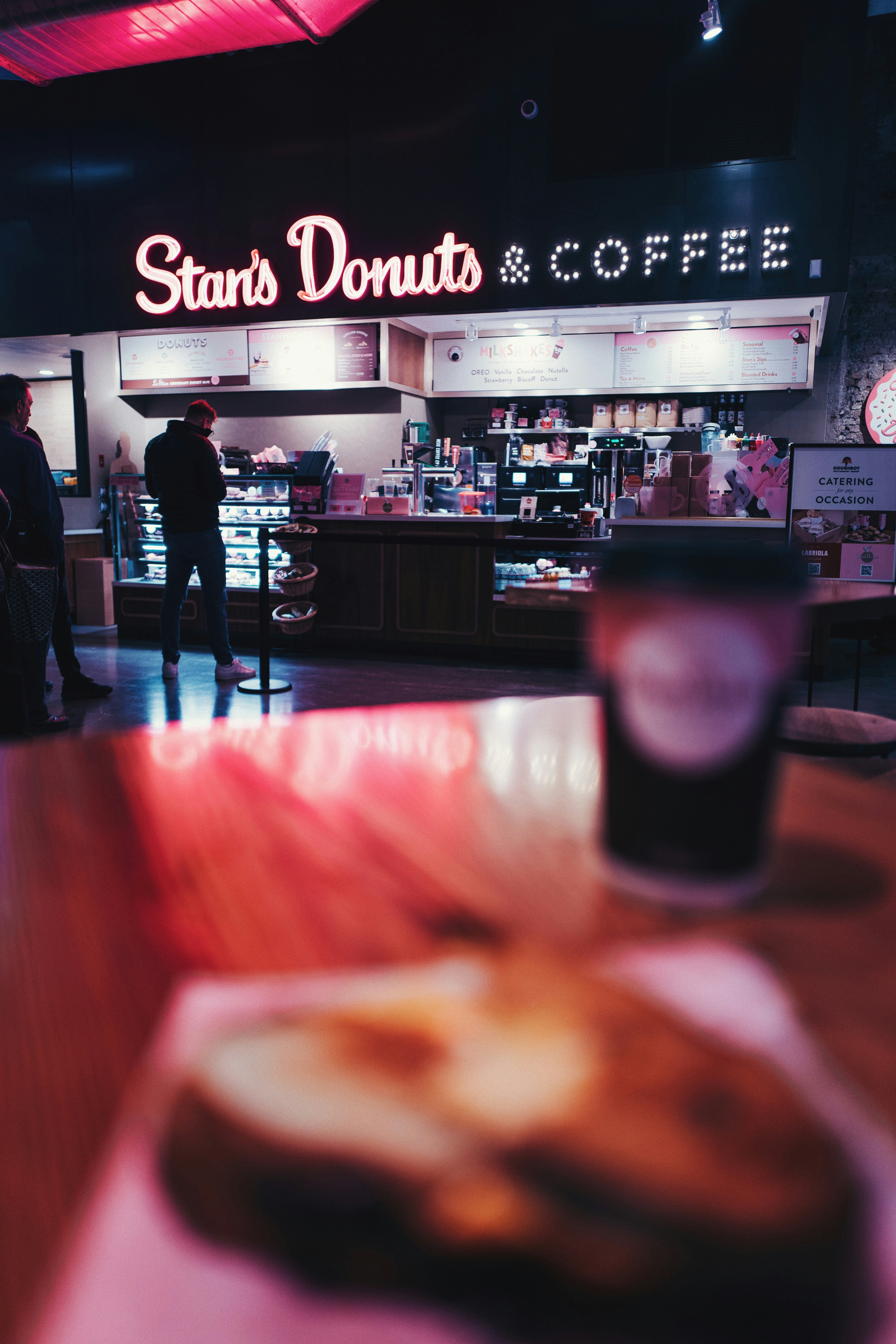 Neon Glow Over Stand's Donuts & Coffee Counter