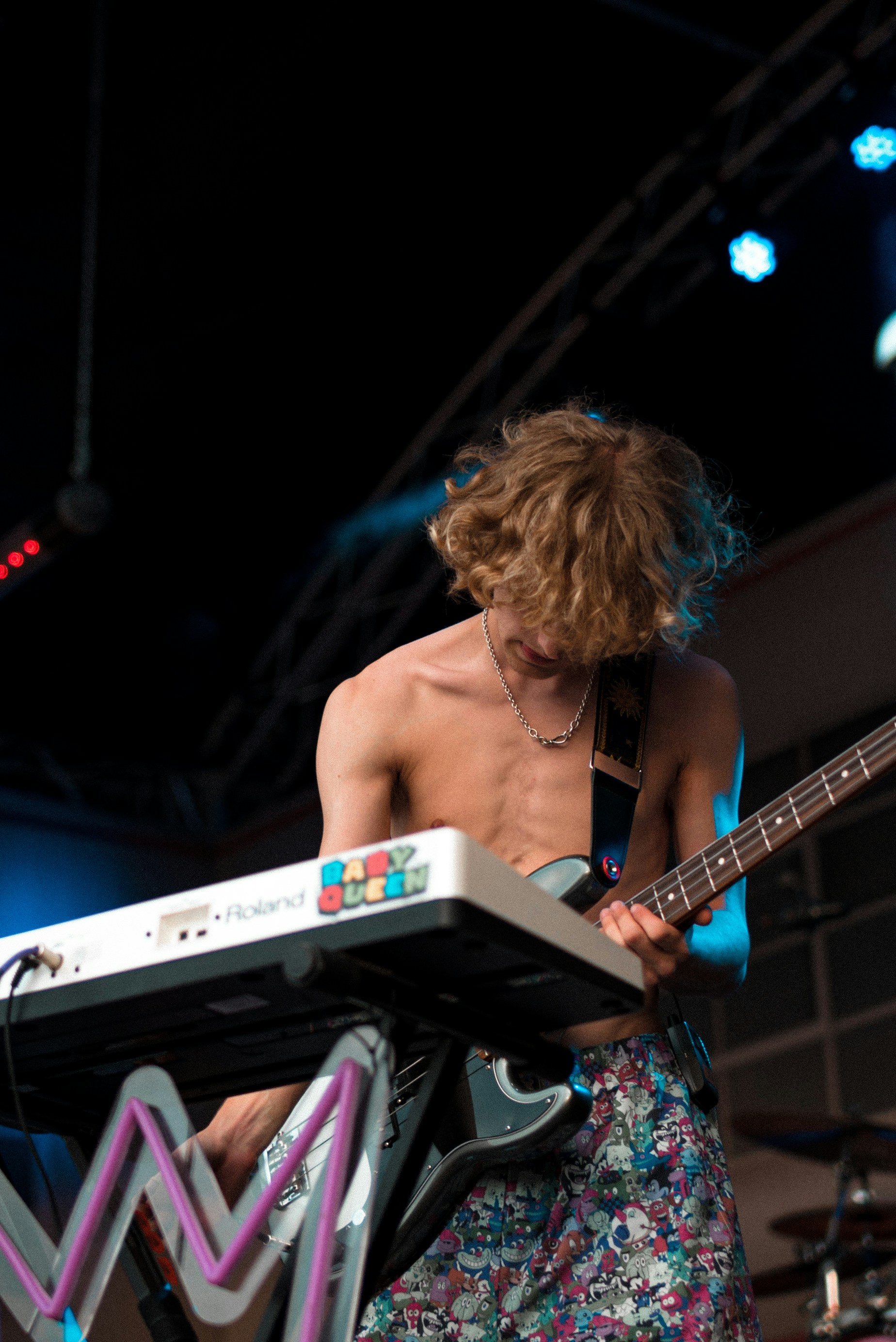 Midnight Keys: A Shirtless Performer Framed by Neon and Music