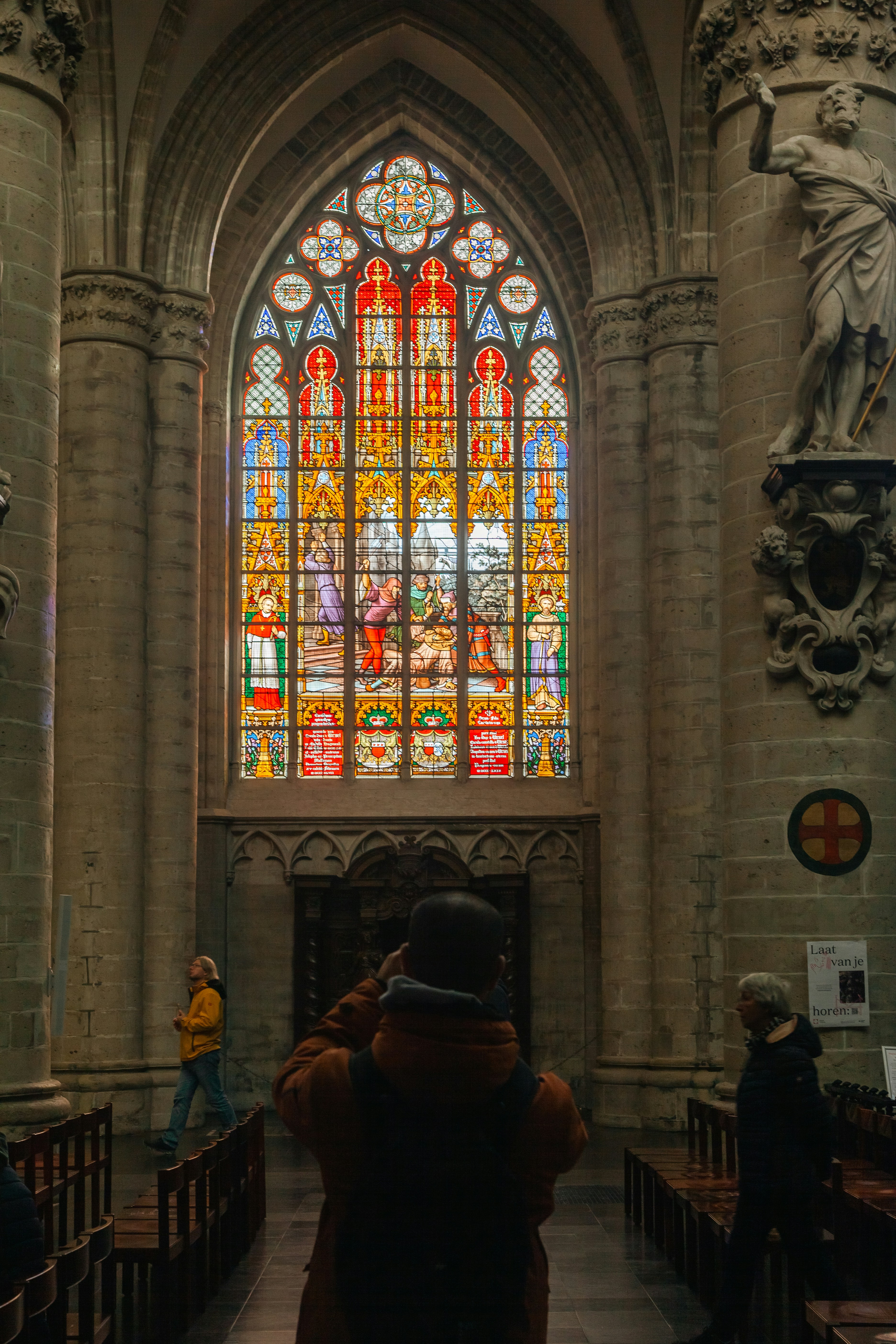 Stained Glass Reverie: Visitors Amid Gothic Light