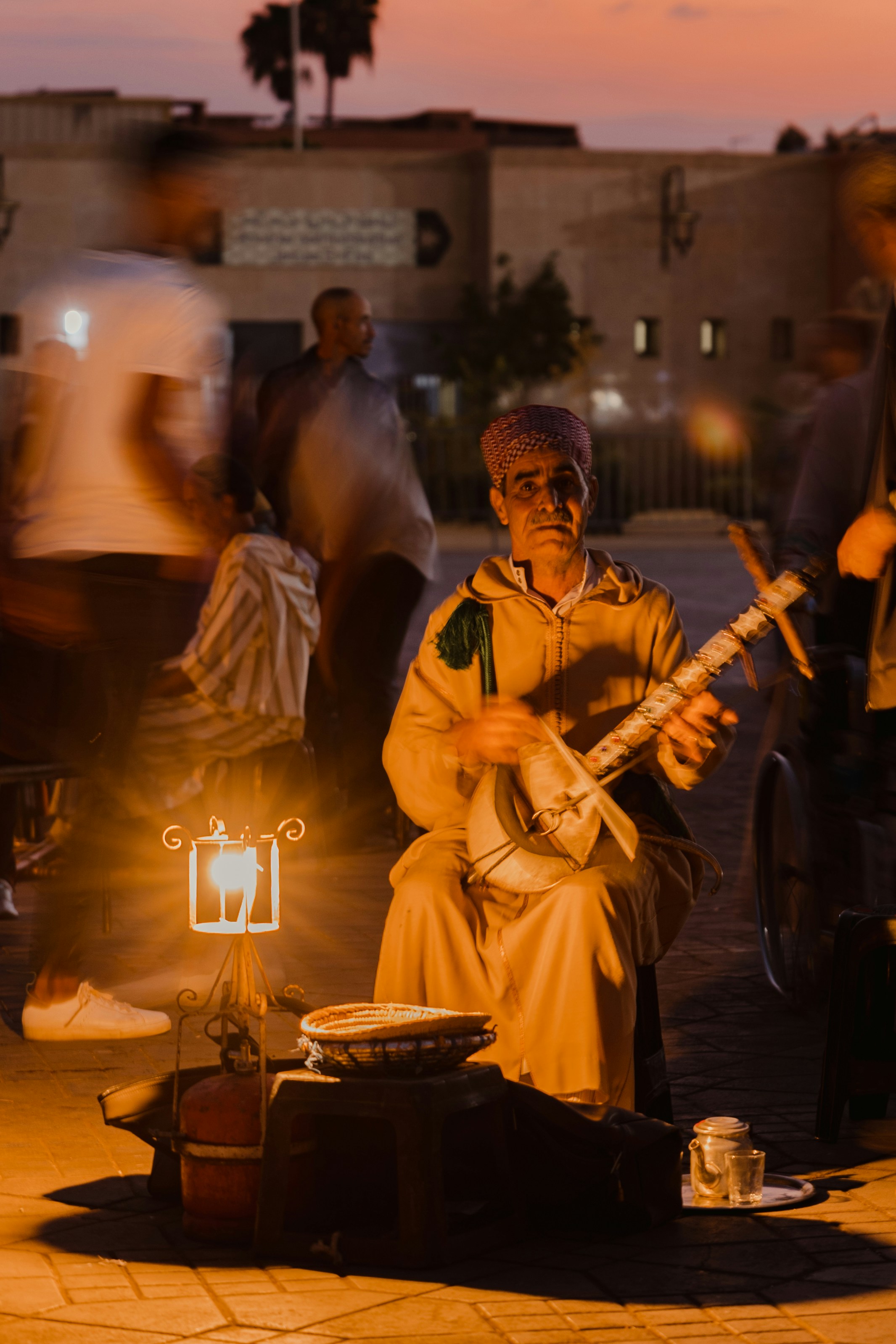 Rabab Under Lantern Light: A Dusk Serenade Amid Passing Shadows