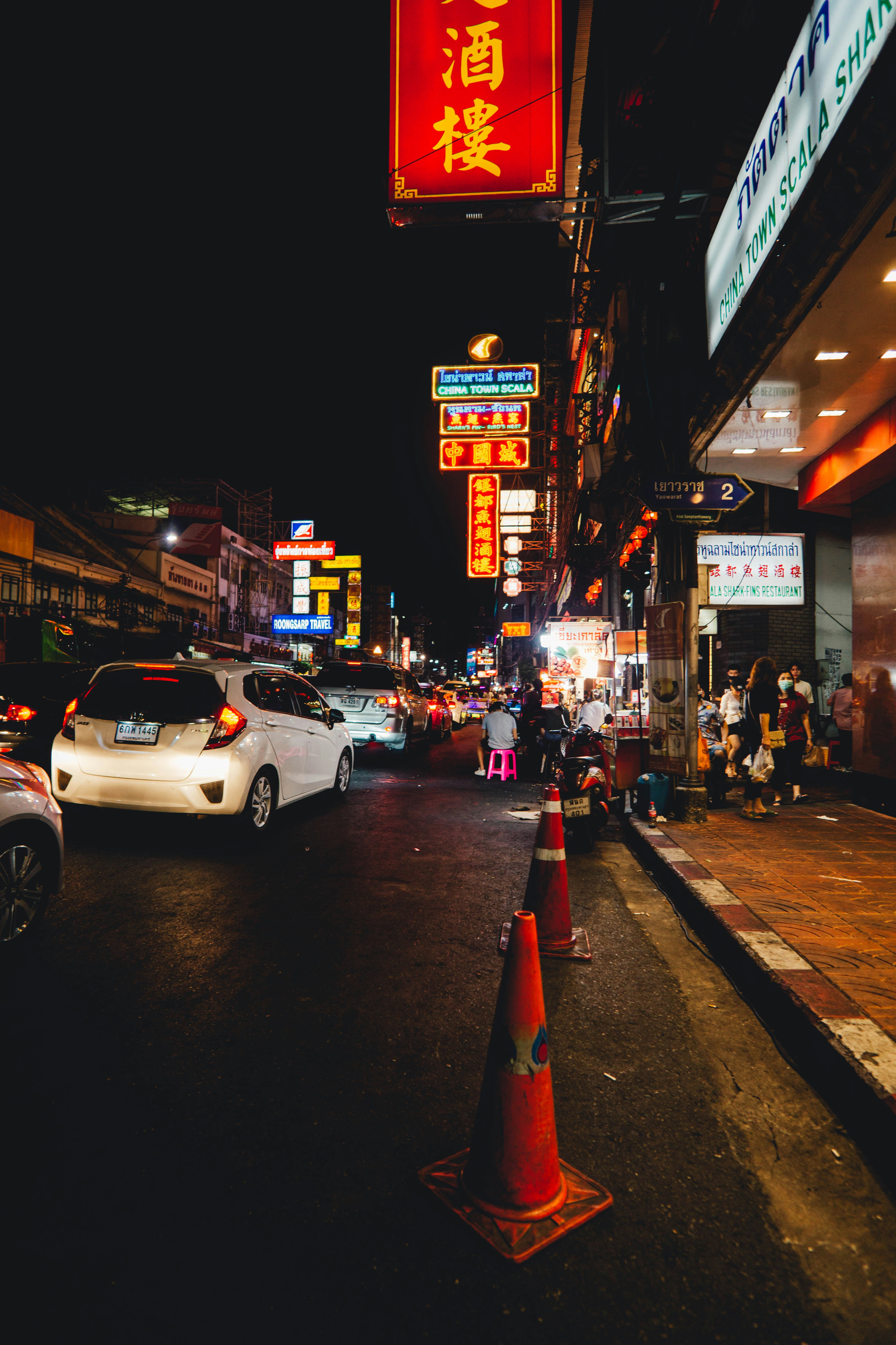 A busy street with signs and traffic cones photo – Free Night Image on ...