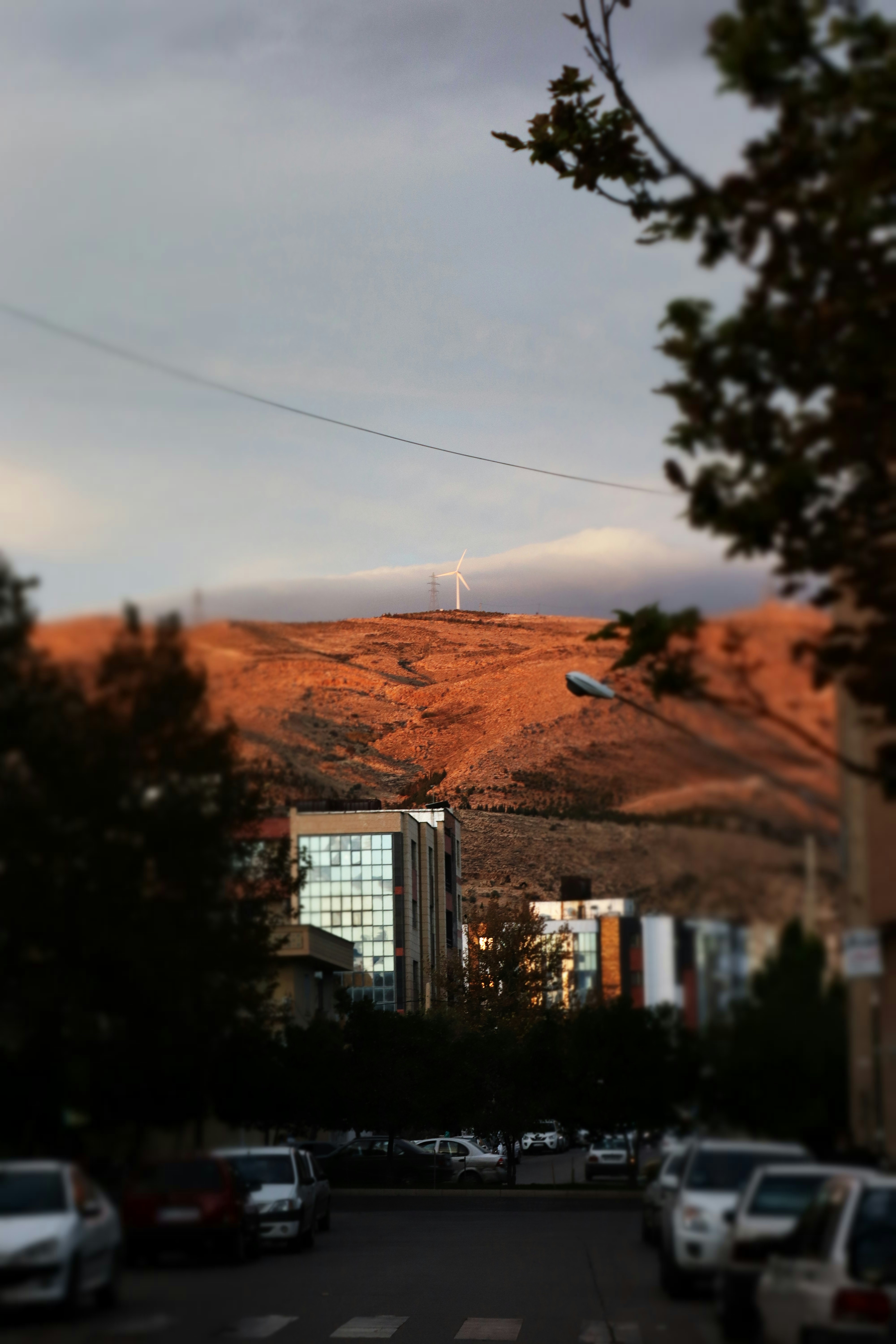 Amber Hills and the Distant Wind Turbine: A City Framed by Dusk