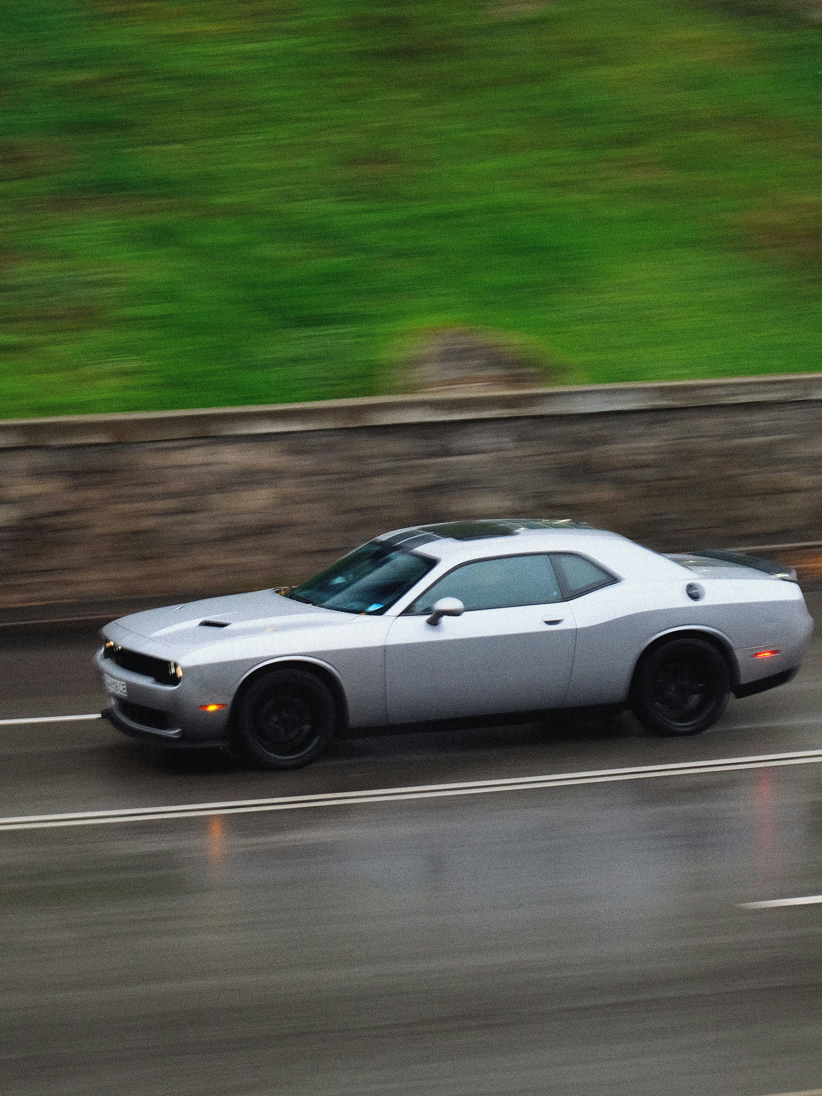 Rain-Soaked Highway Blur: White Muscle Car in Mid-Run