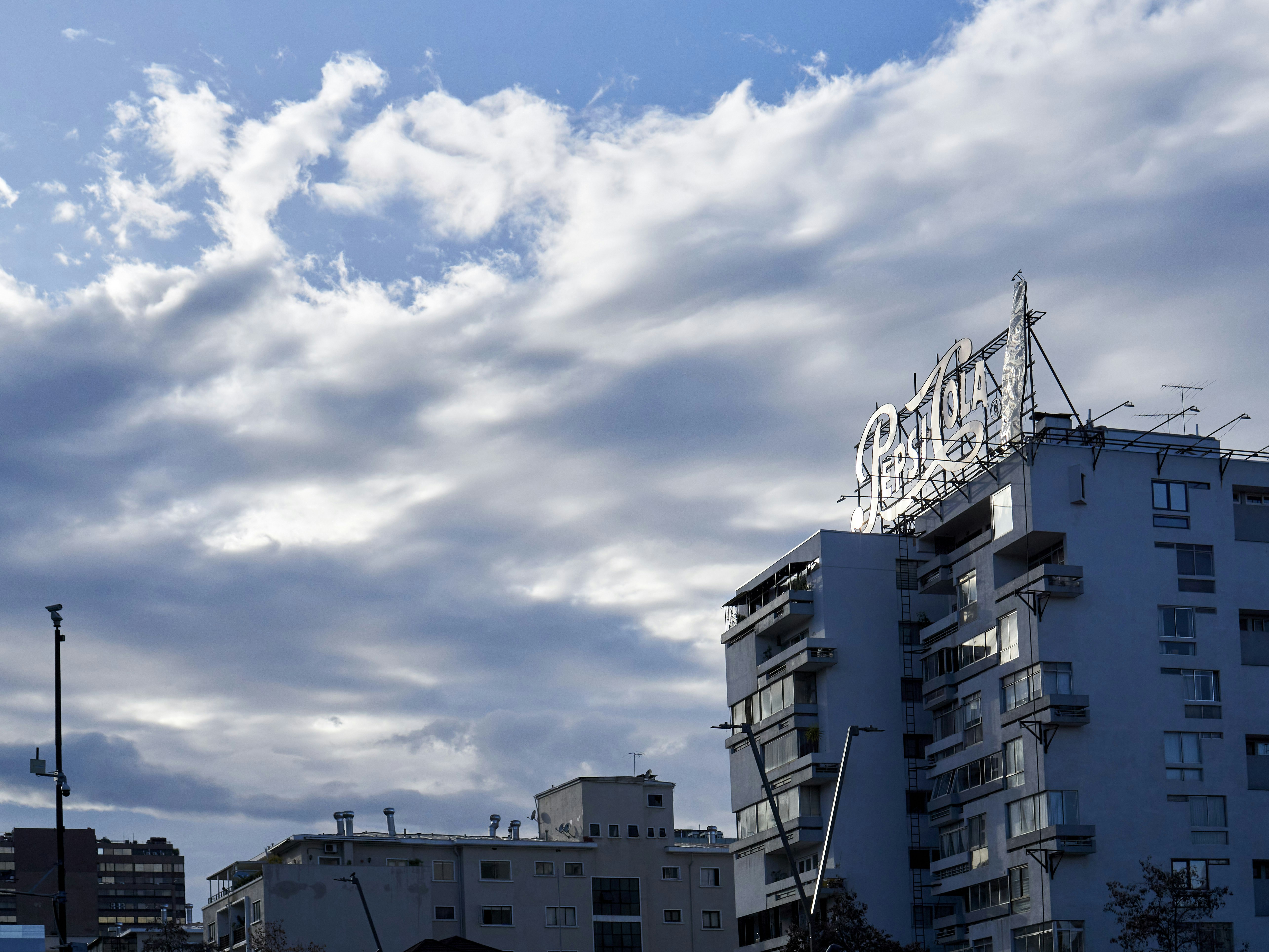 A group of buildings with clouds above photo – Free Santiago Image on ...