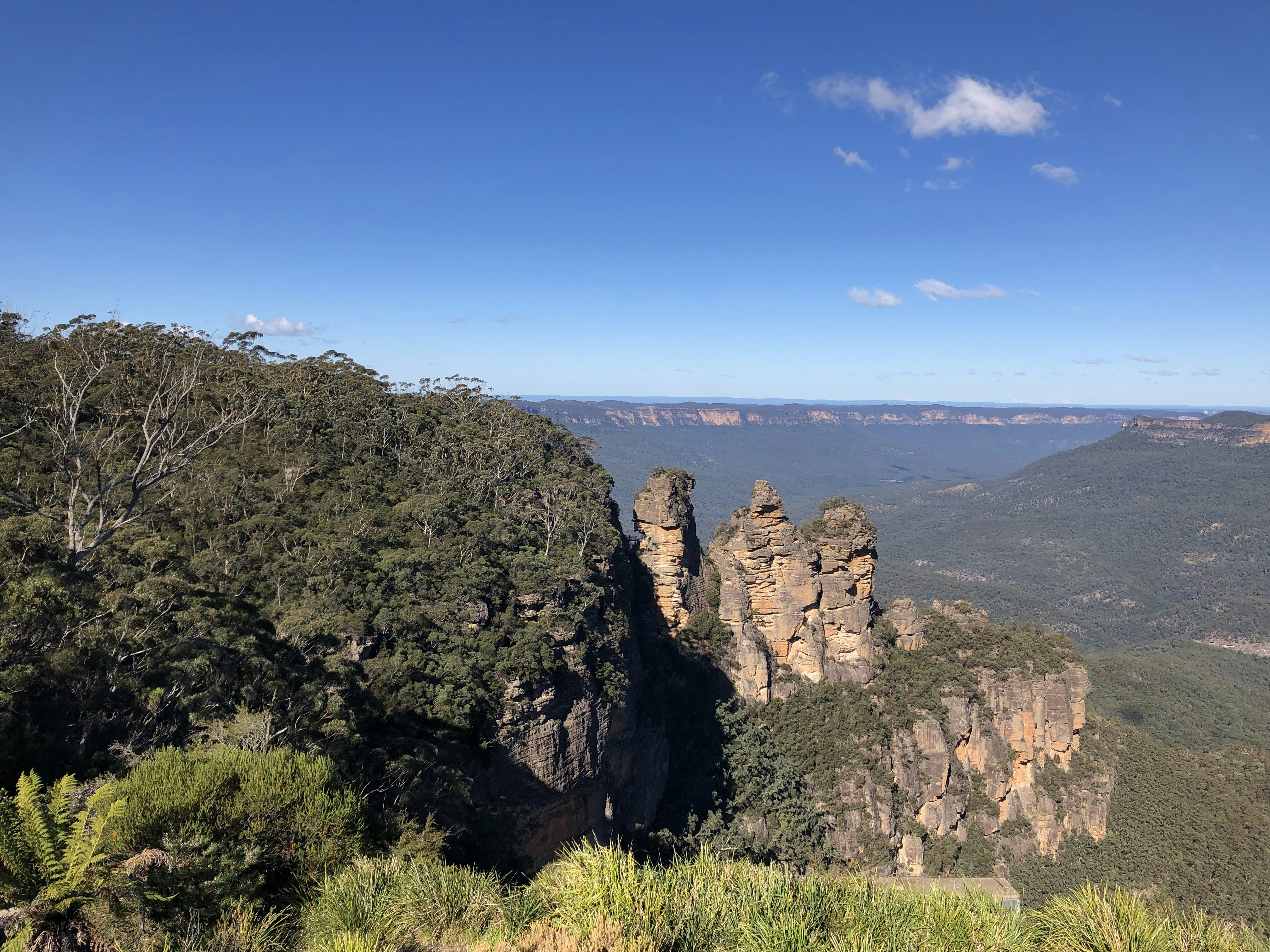 Une falaise rocheuse avec des arbres et un plan d’eau au loin photo ...