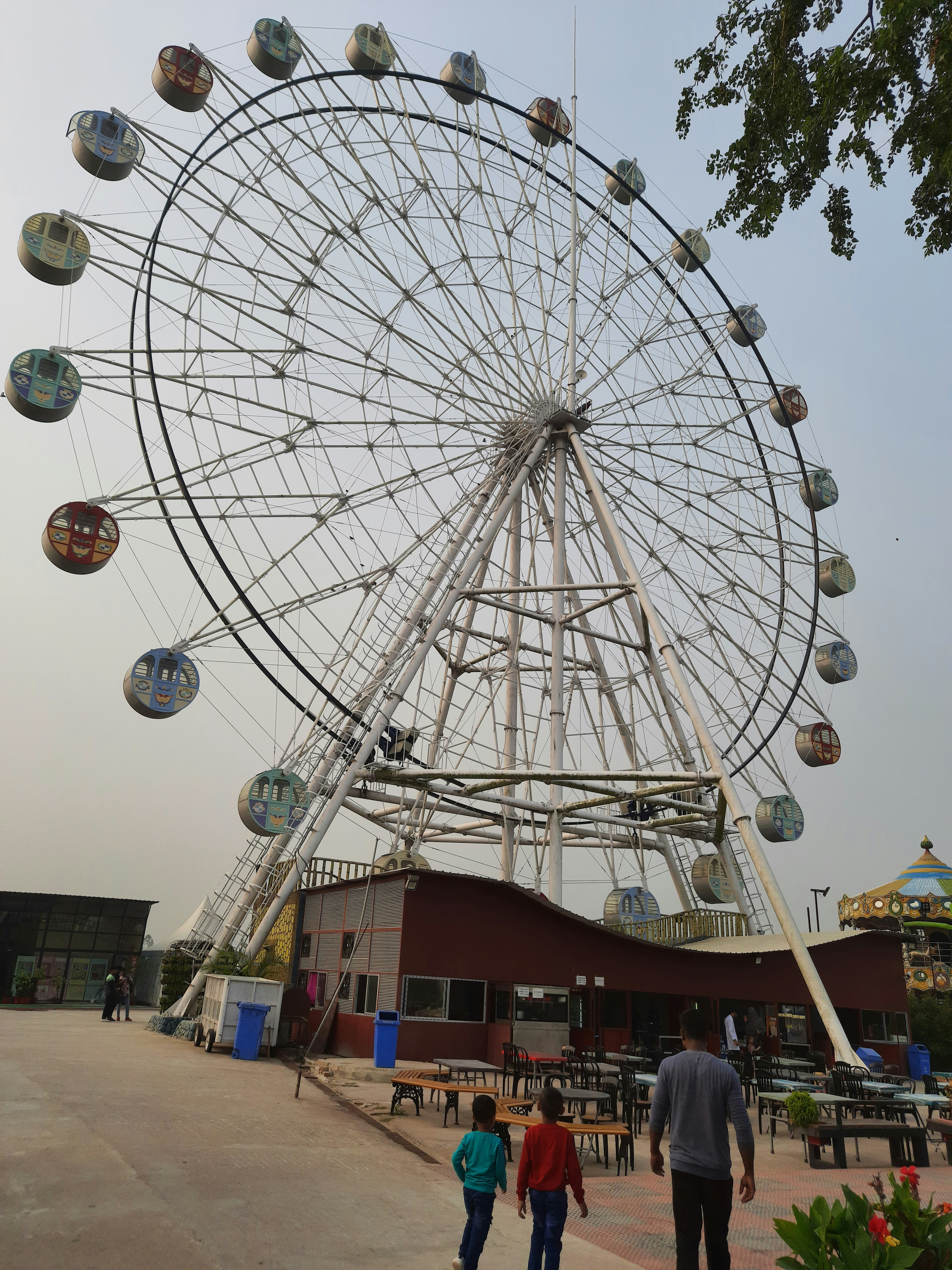 Monumental Ferris Wheel Crowned by Clear Sky Over a Quiet Fairground