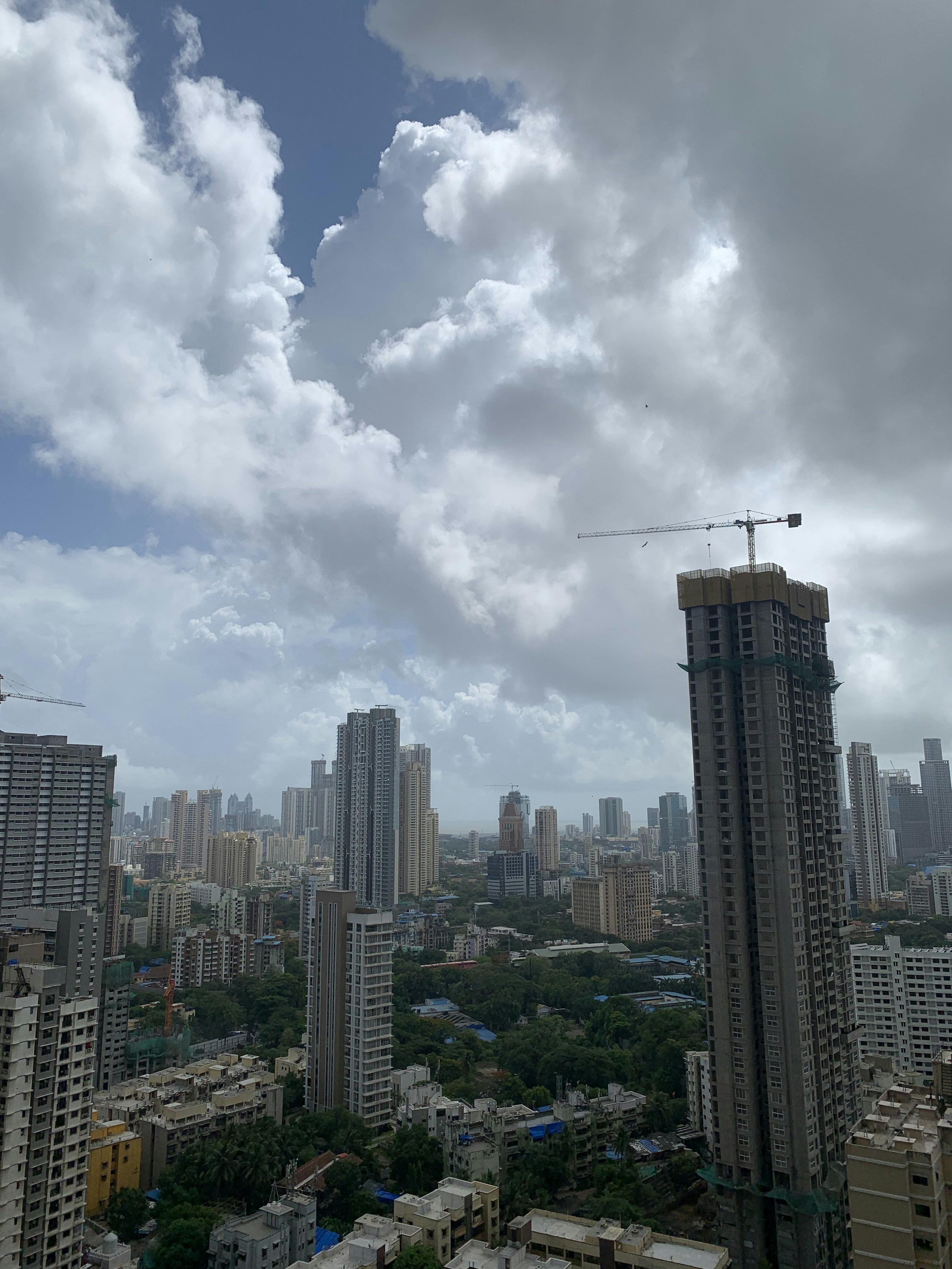 Cranes Crown the City: A Skyline Rising Beneath a Cloud-Dusted Sky