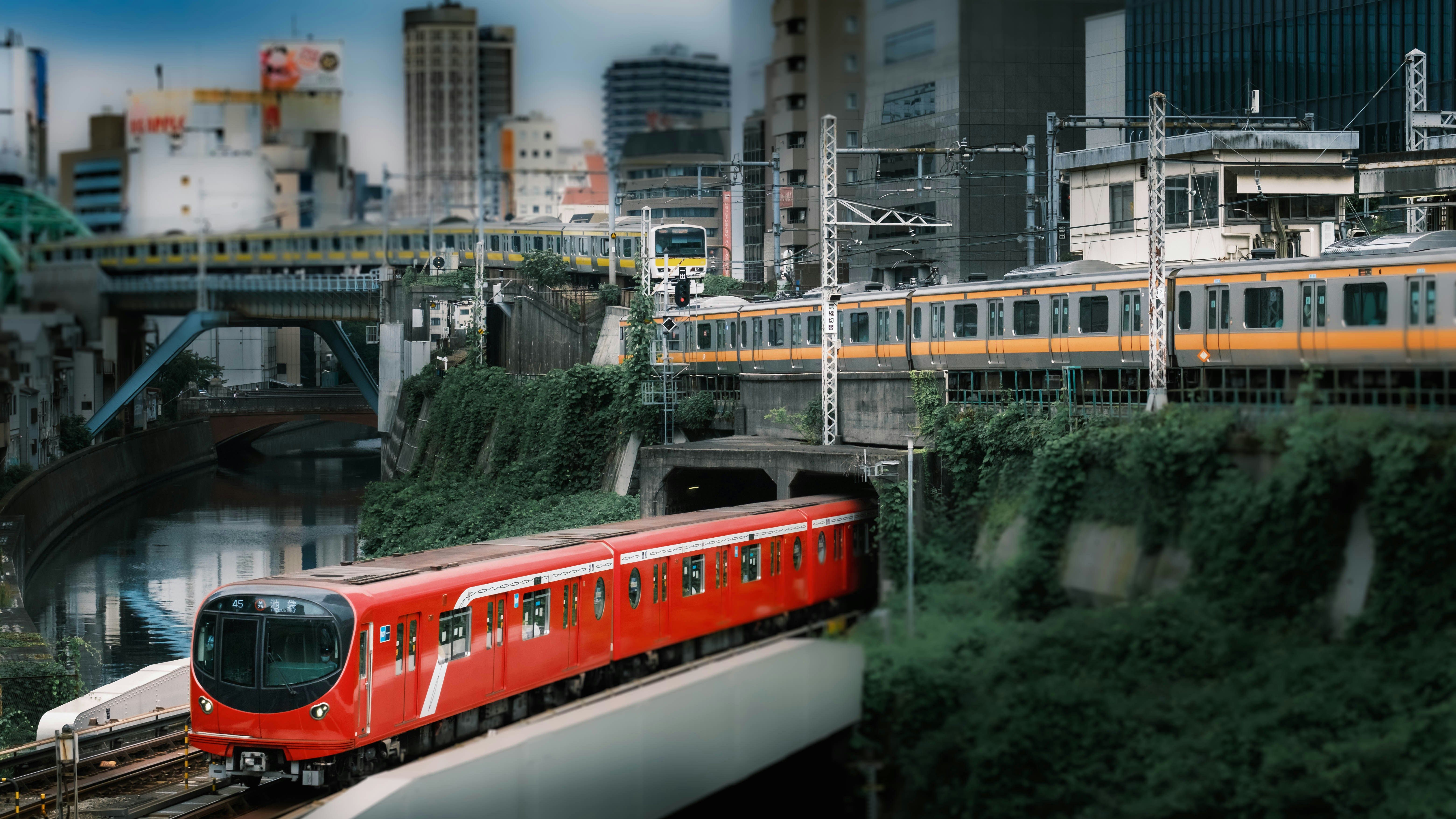 Red Commuters: A Glimpse of Urban Rails Winding Through Steel and Sky