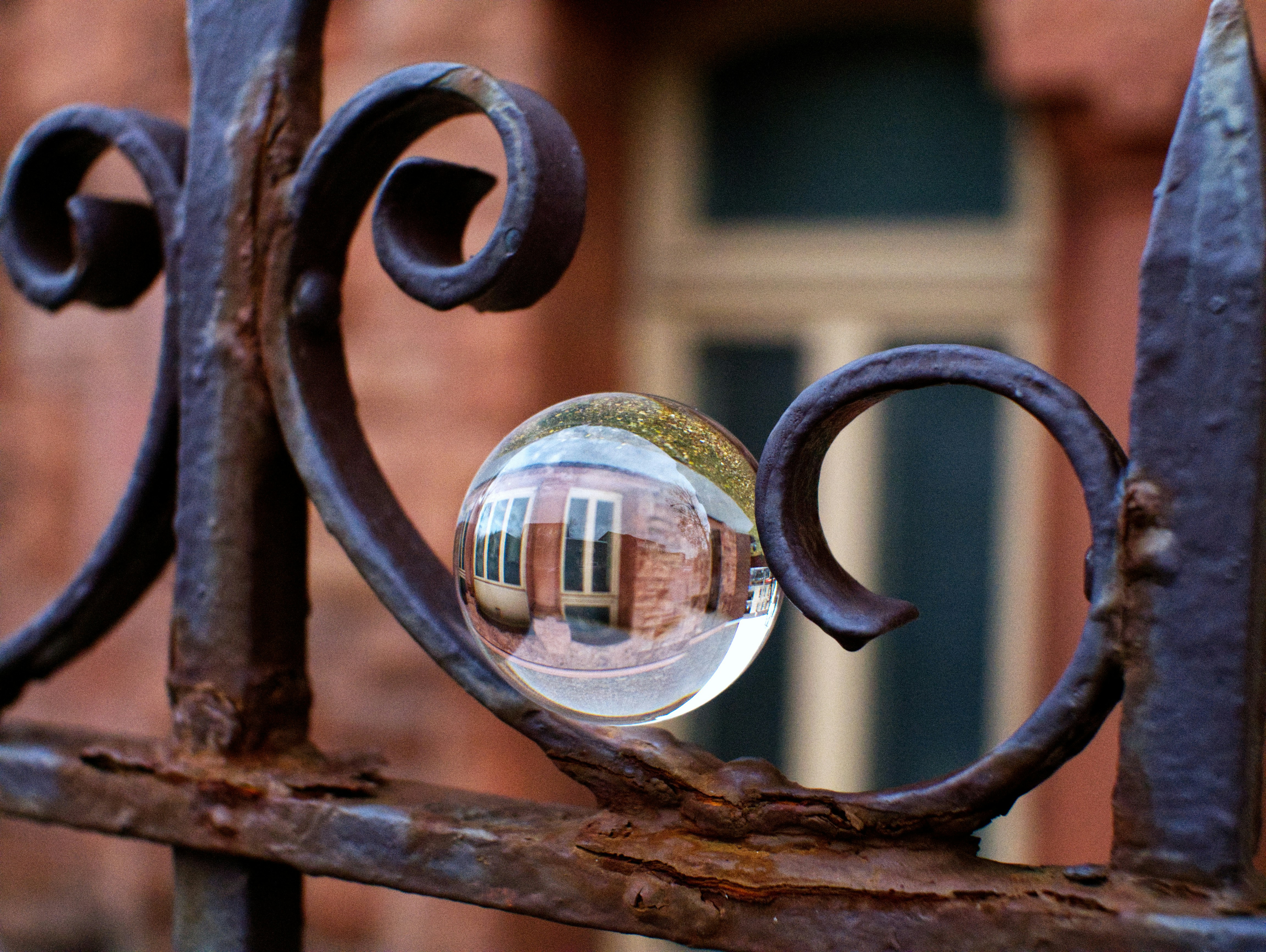 Crystal Ball on Rusted Iron: An Inverted Brick Facade Framed by Curling Scrolls