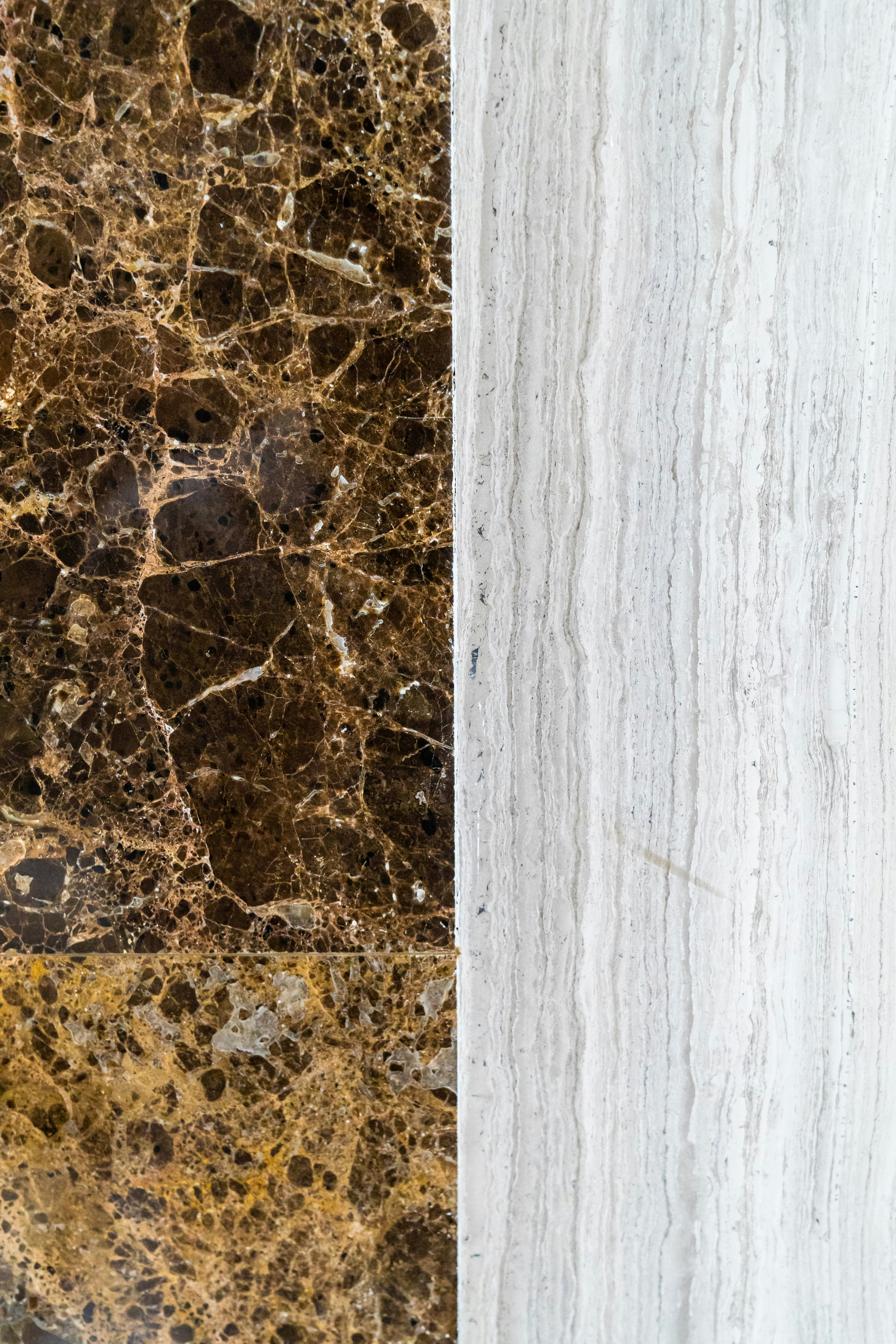 Vertical Divide: Dark Mosaic Marble Meets Pale Striated Stone