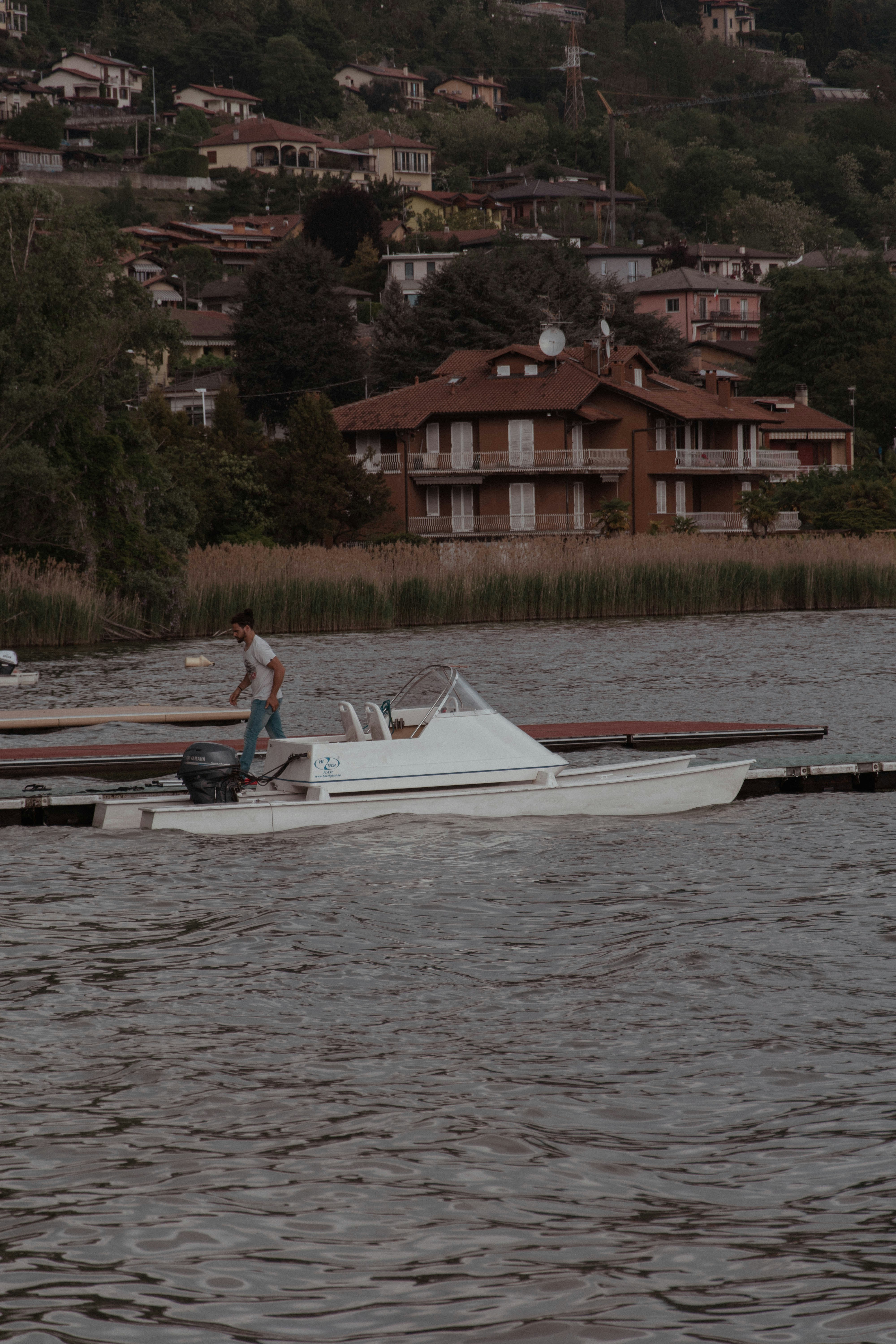 Evening Quiet on the Lake: A Lone White Boat by a Hillside Village