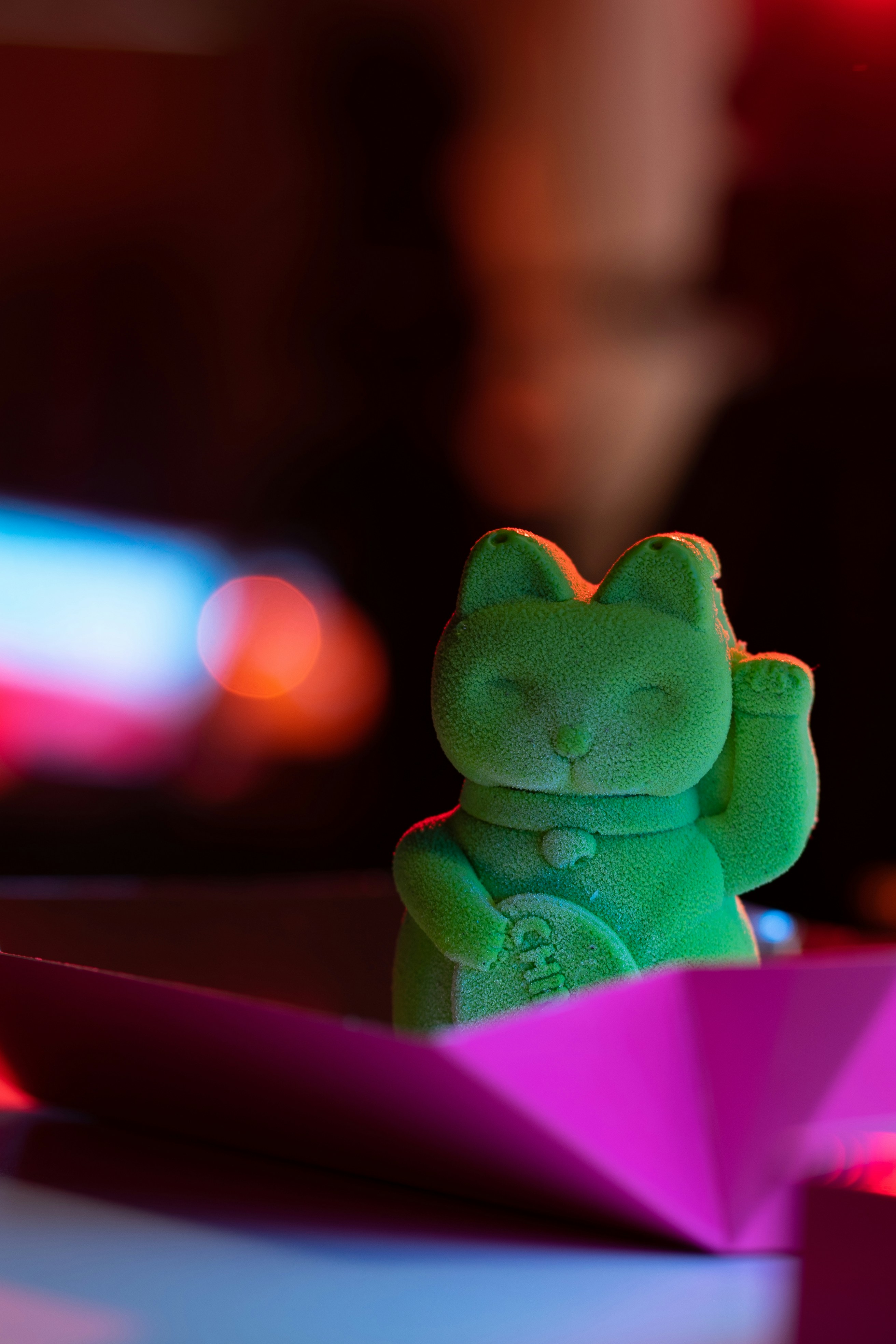 Emerald Maneki-neko in Neon Glow Among Pink Origami