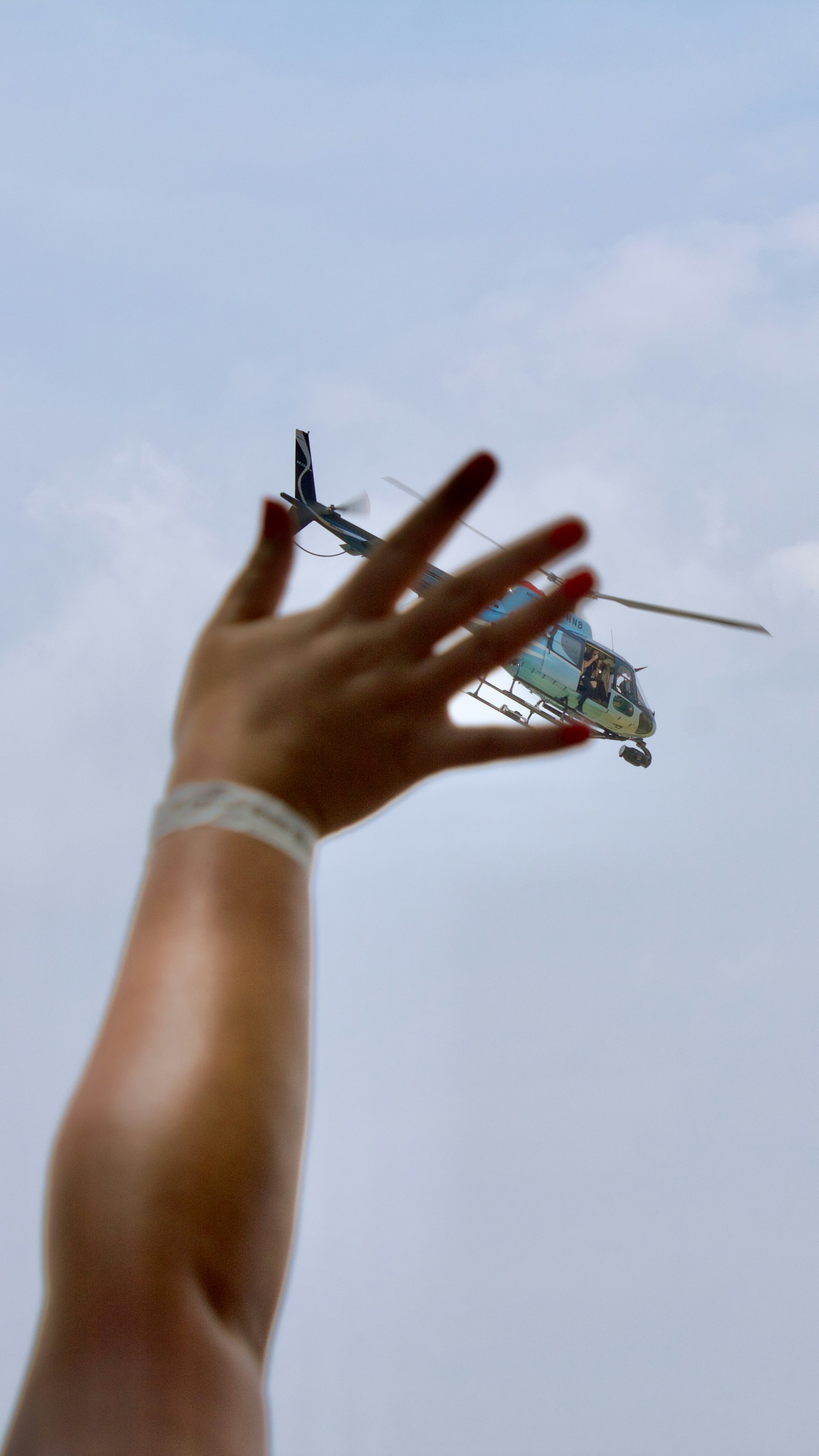 Rising Helix: A Helicopter Emerges Beyond a Blurred Hand