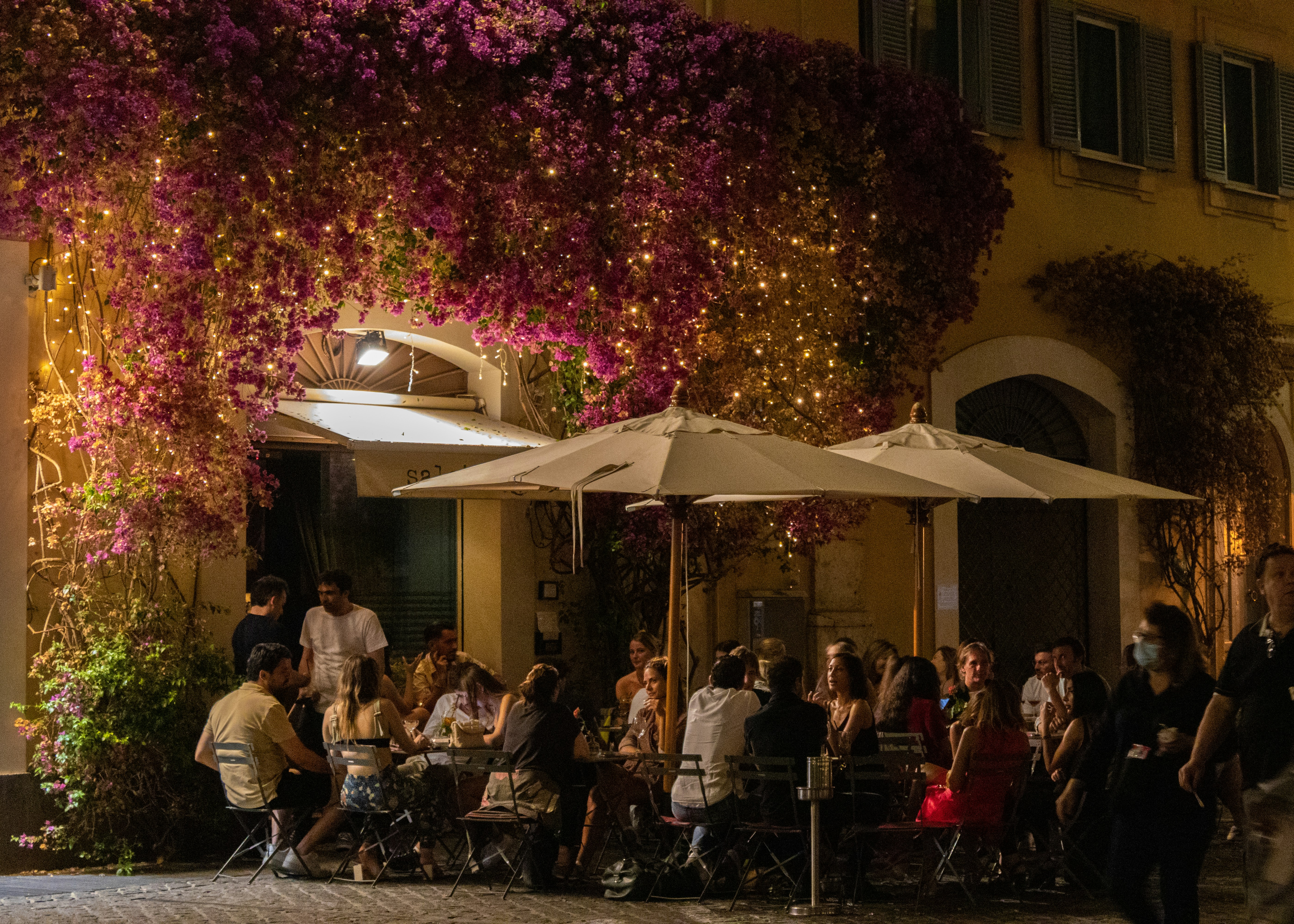 Evening Mosaic: Café Lights and Conversing Shadows