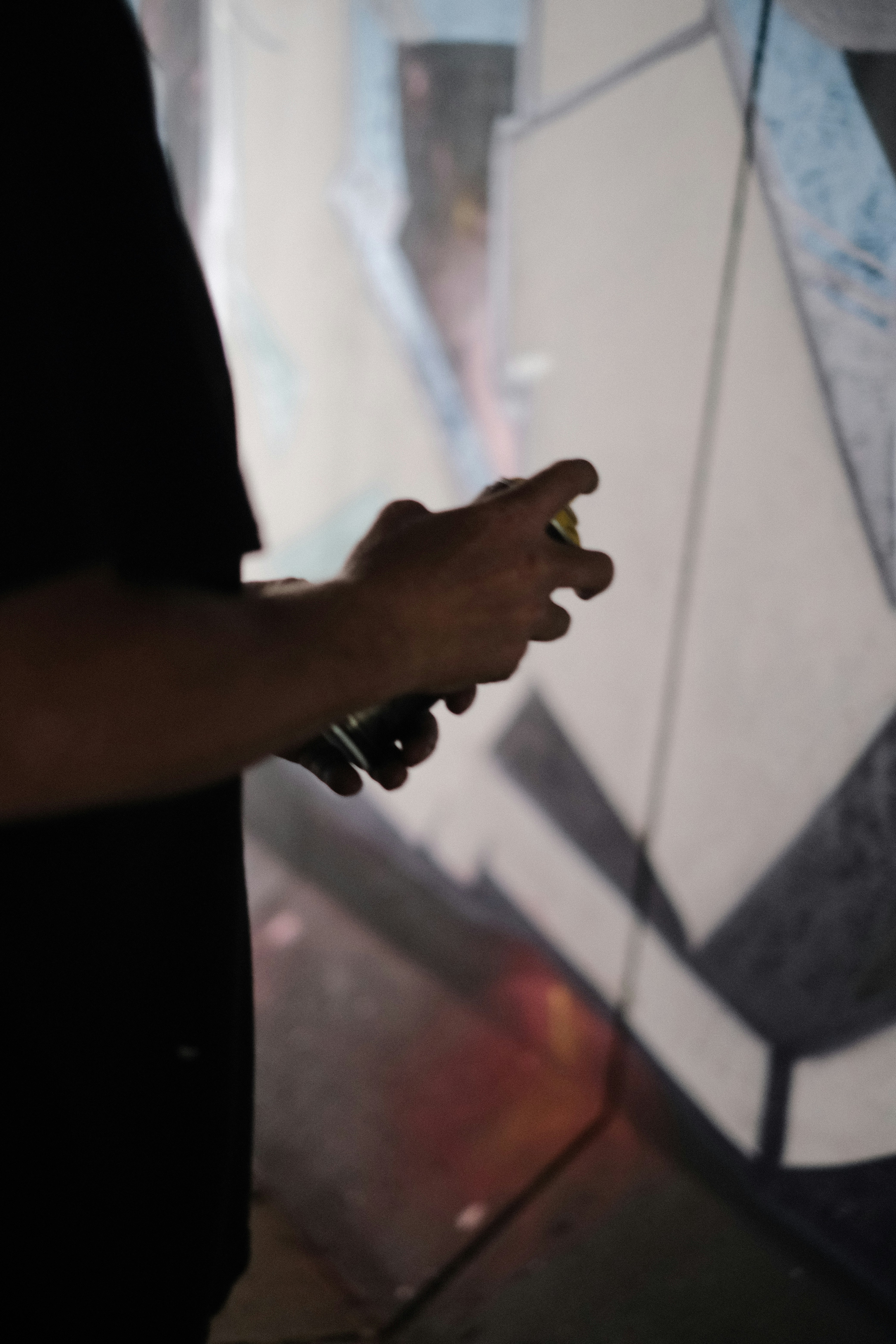 The Quiet Tag: Hand with Spray Against a Geometric Graffiti Backdrop
