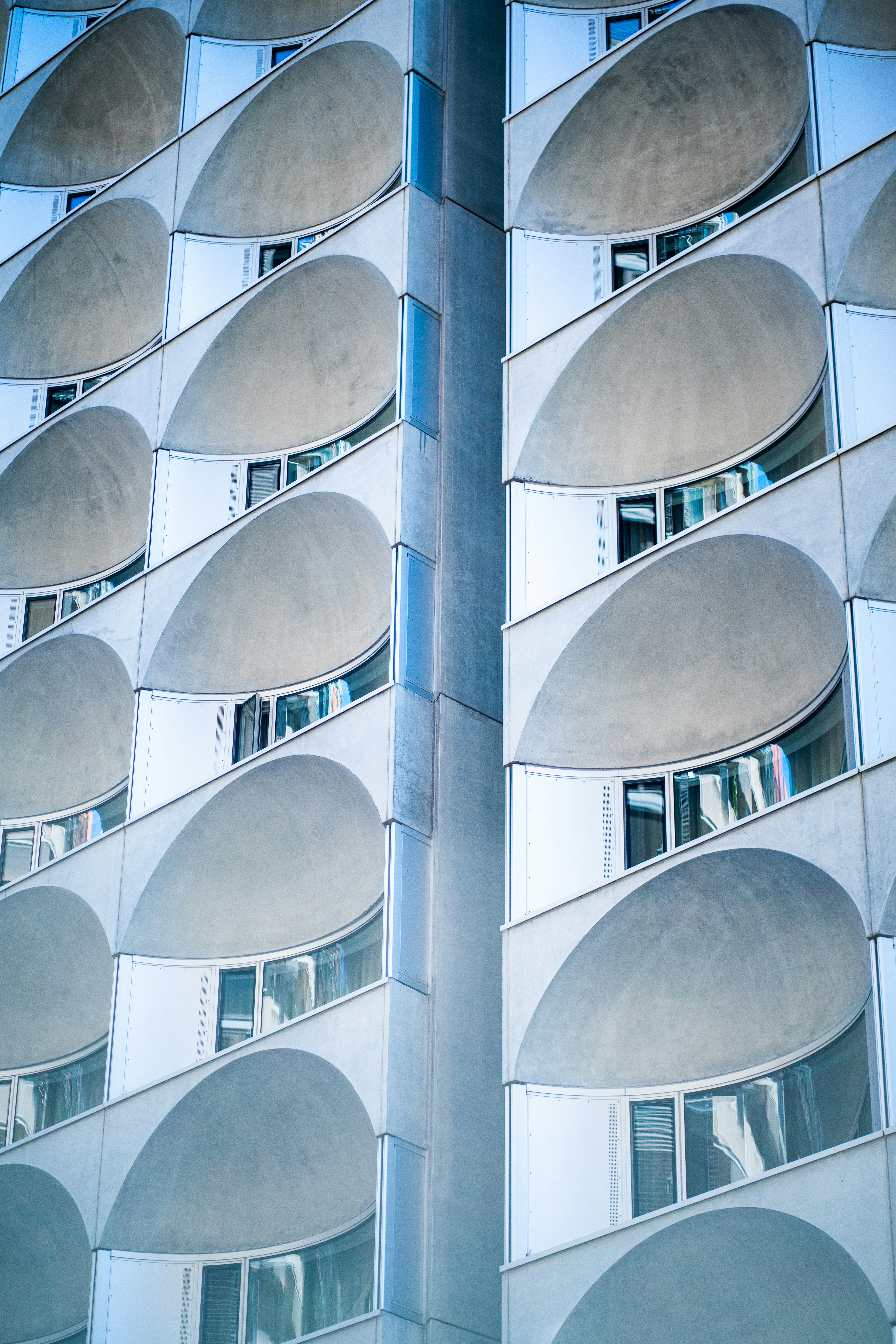 Vertical Orbit: Echoes of Circles on a Mint-Blue Facade
