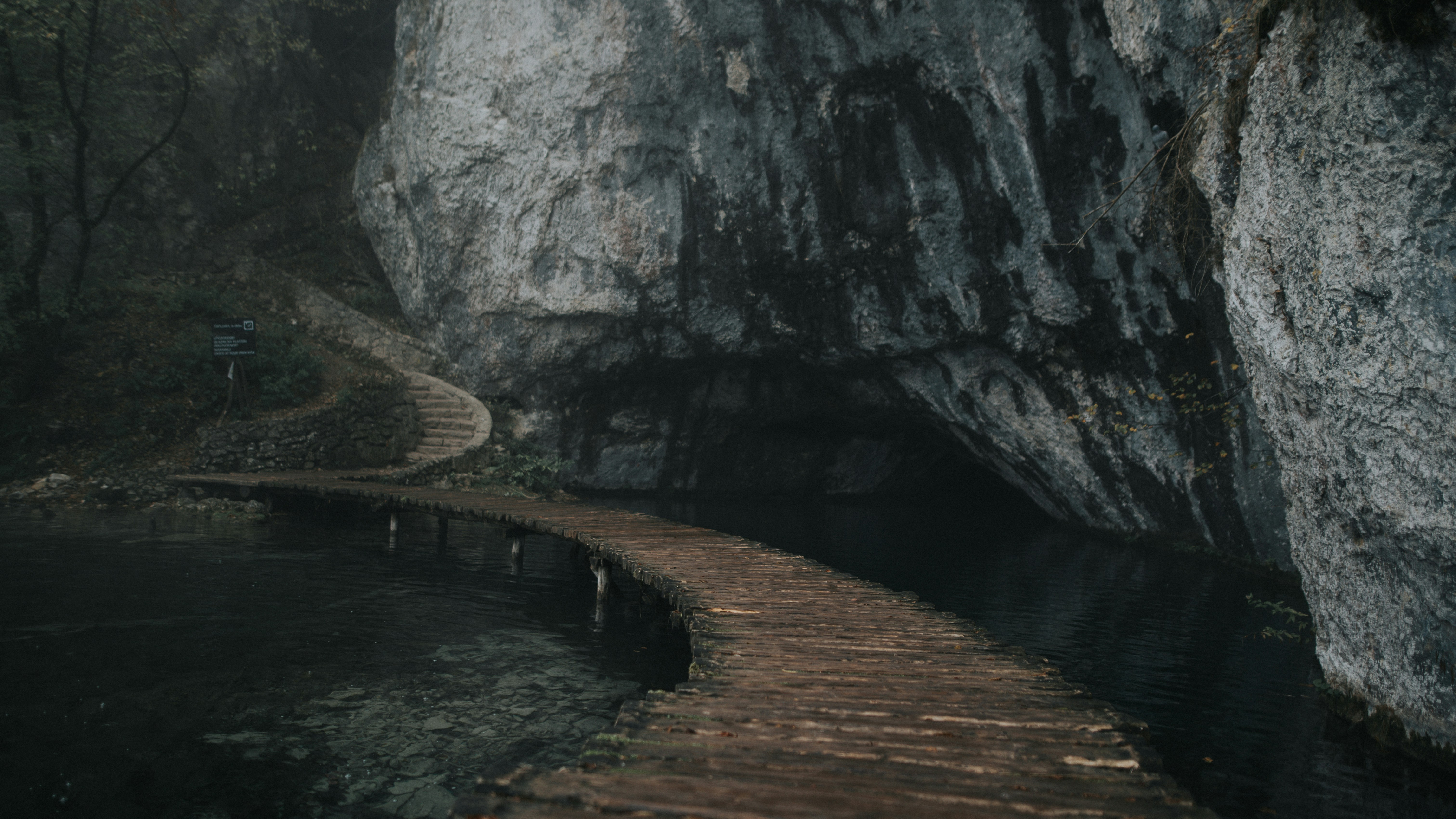 Shadowed Grotto Curve: A Wooden Path Through Limestone