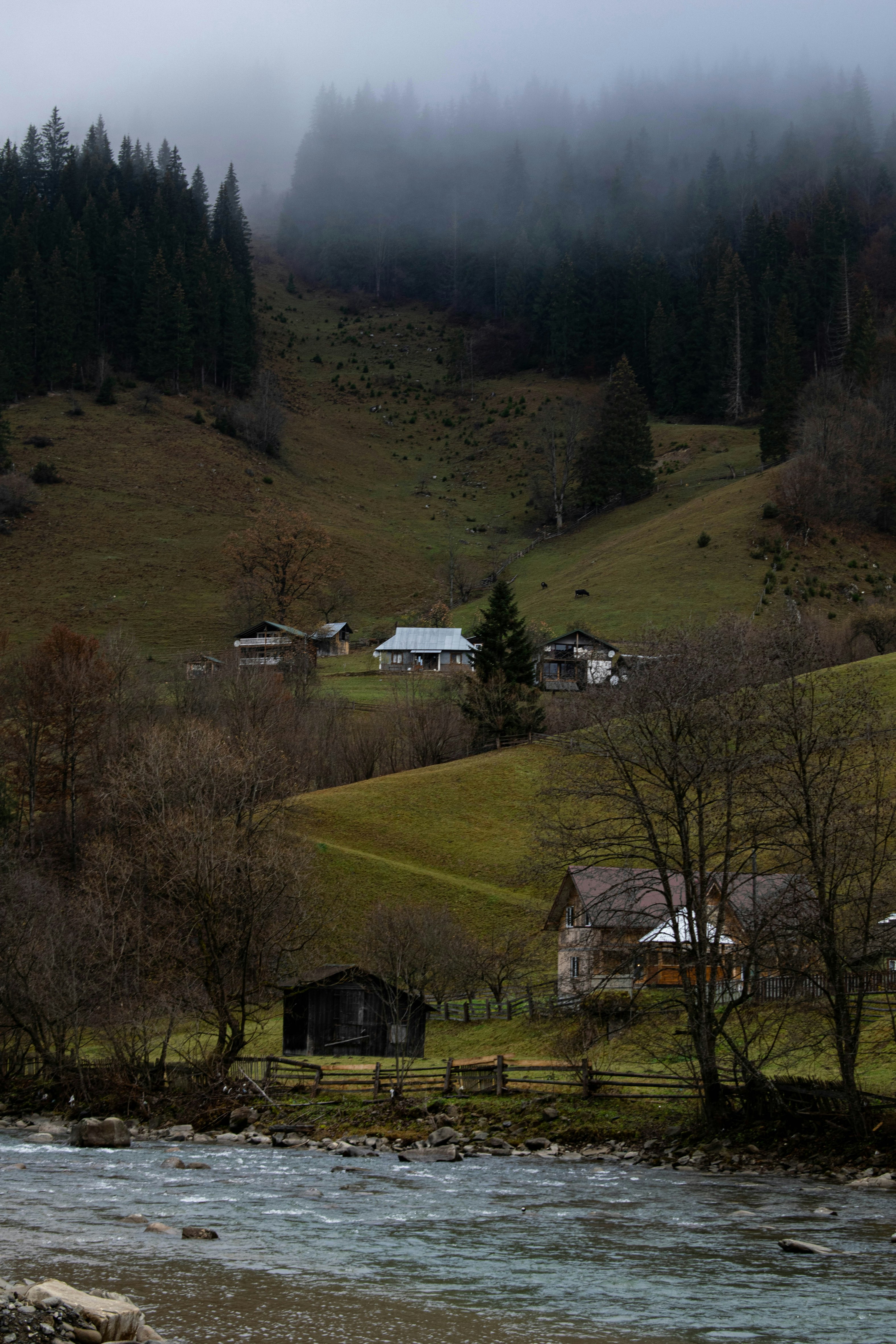 Foto zum Thema Ein Fluss, der durch ein Tal fließt, mit Häusern und ...