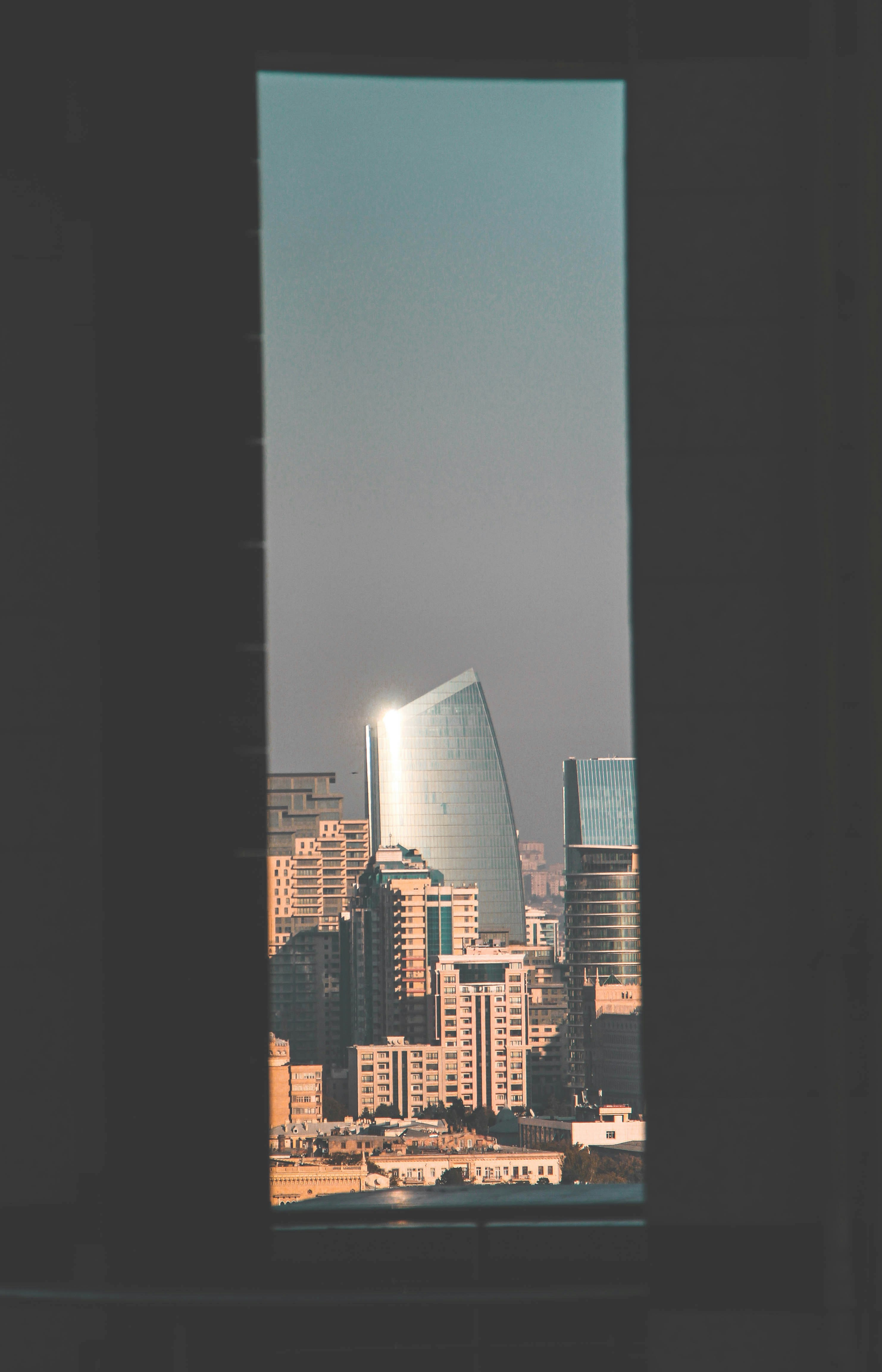 Glint Through a Narrow Frame: Morning Skyline on Glass and Steel