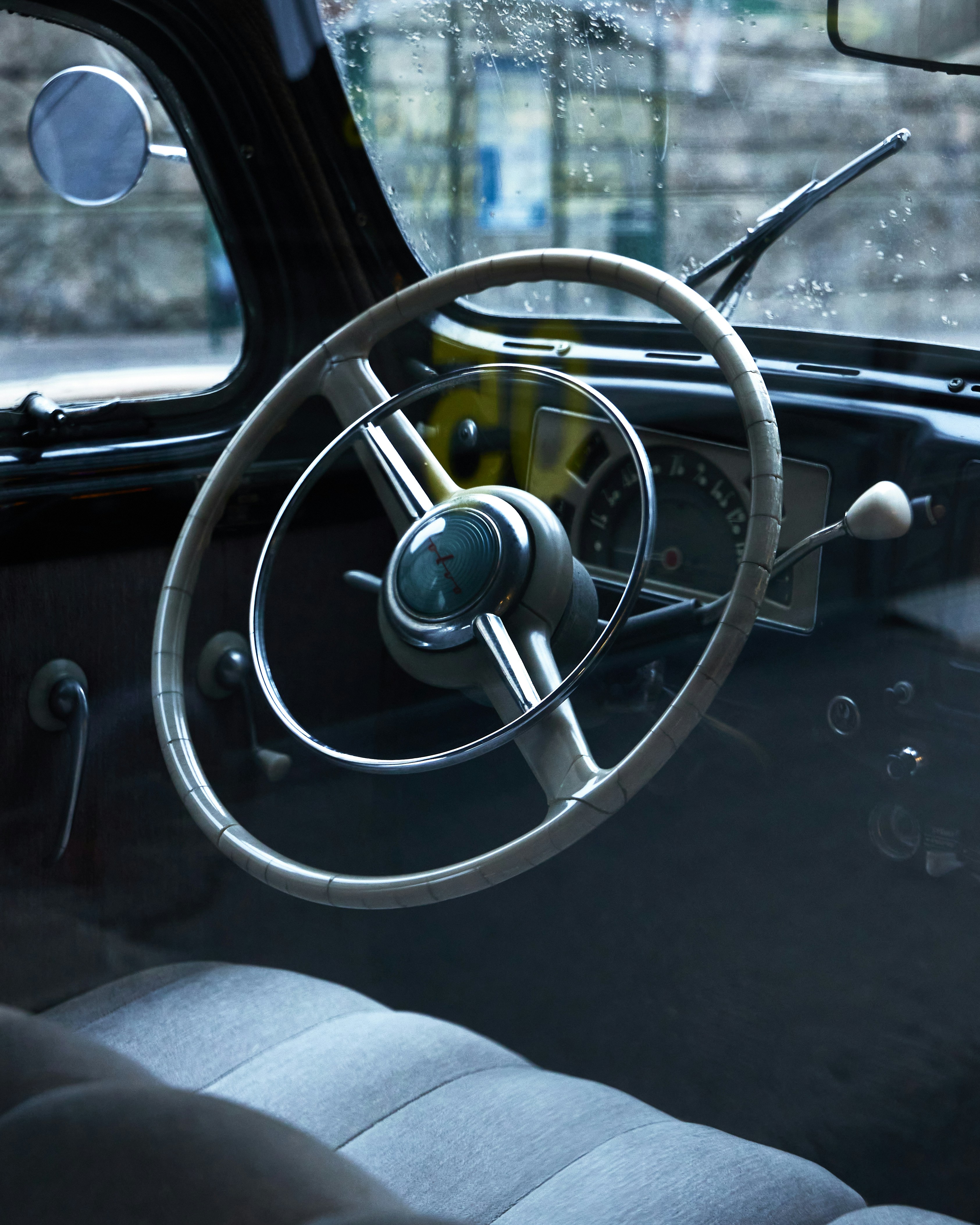 Chrome Halo: The Vintage Steering Wheel in a Rain-Dusted Cabin