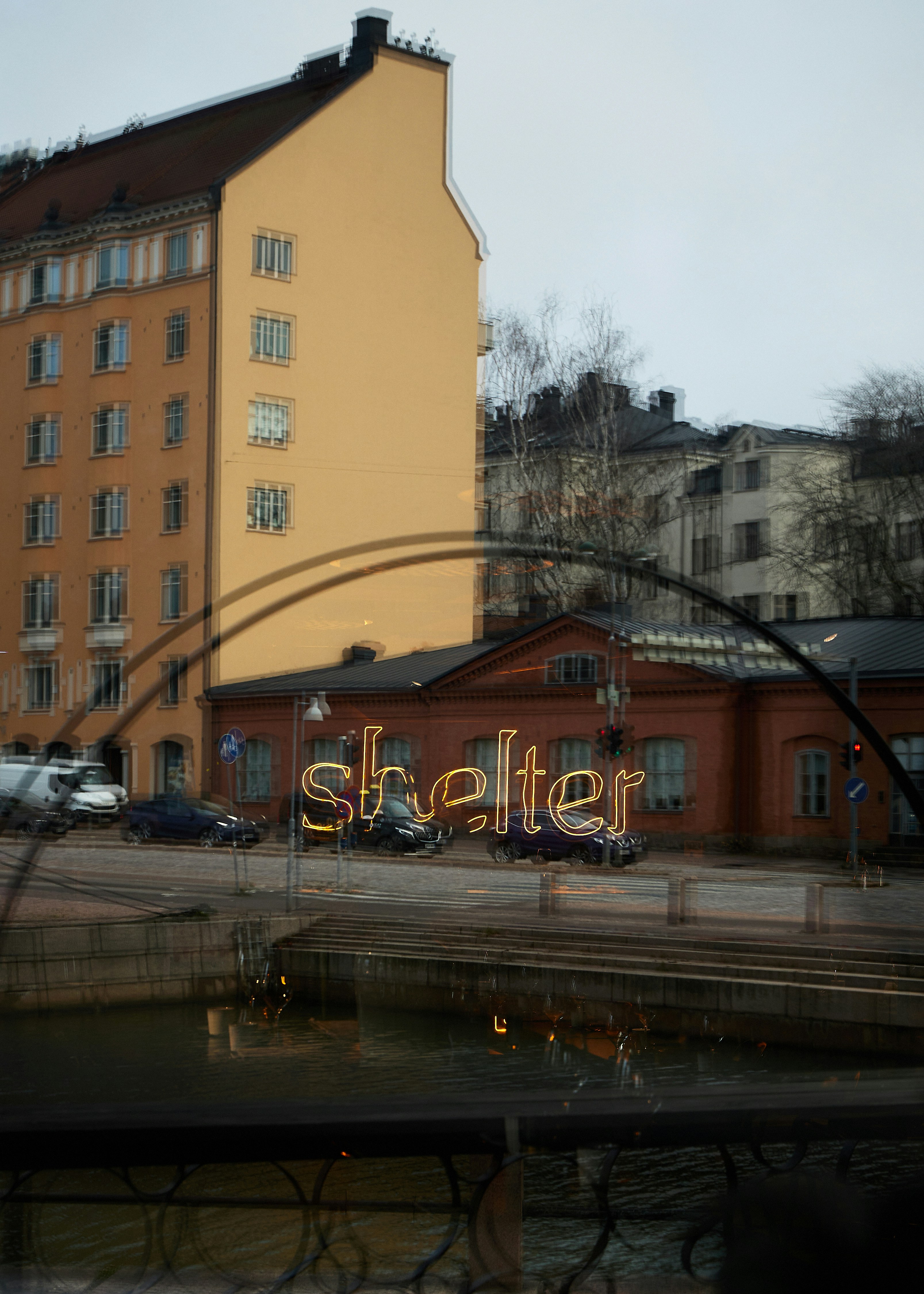 Shelter Neon by the Canal: Reflected Glow Between Yellow Facades and Red Brick