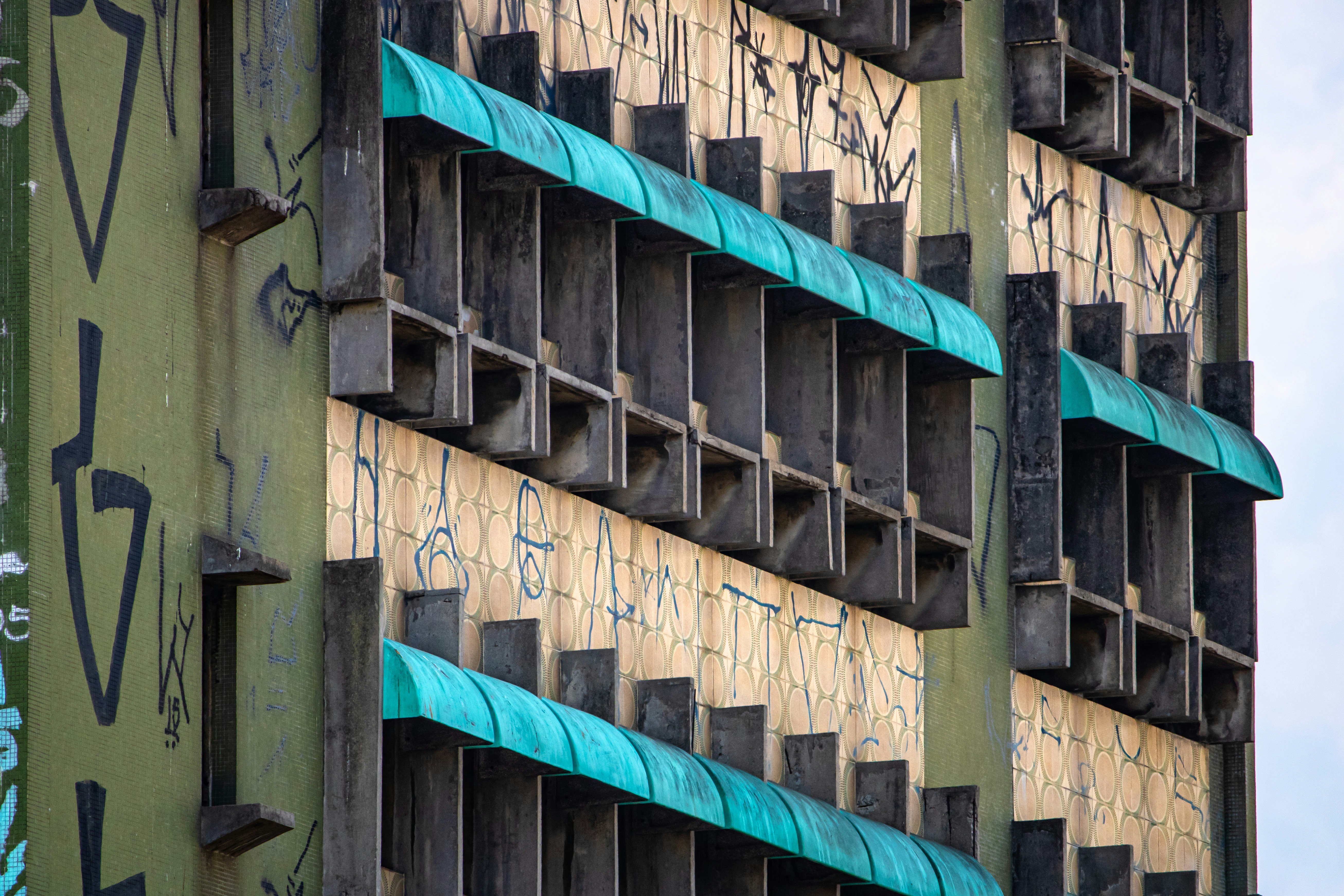 Teal Rails Carve Rhythm Across a Graffiti-Washed Facade