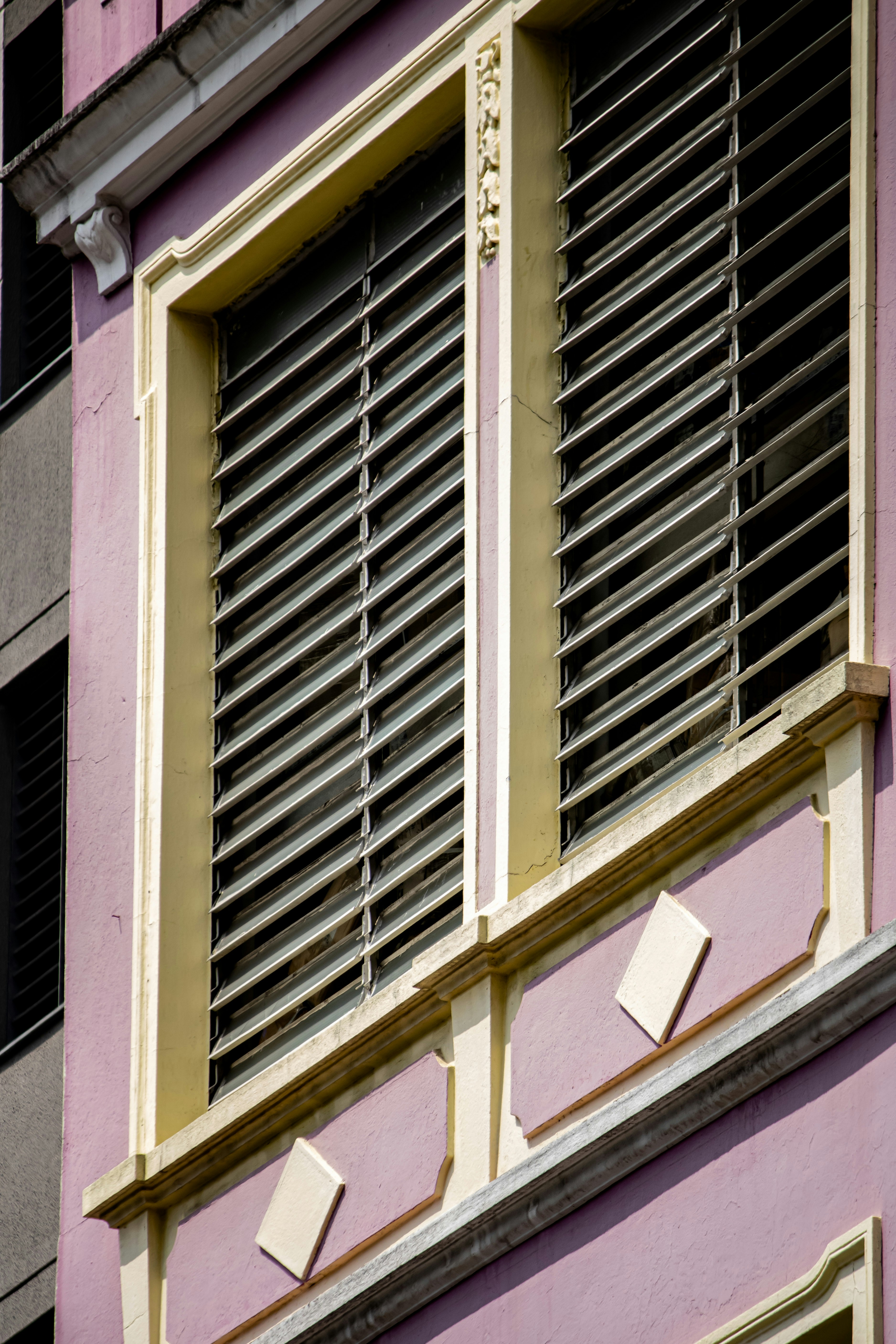 Pastel Facade in Focus: Diamond Accents and Louvered Windows
