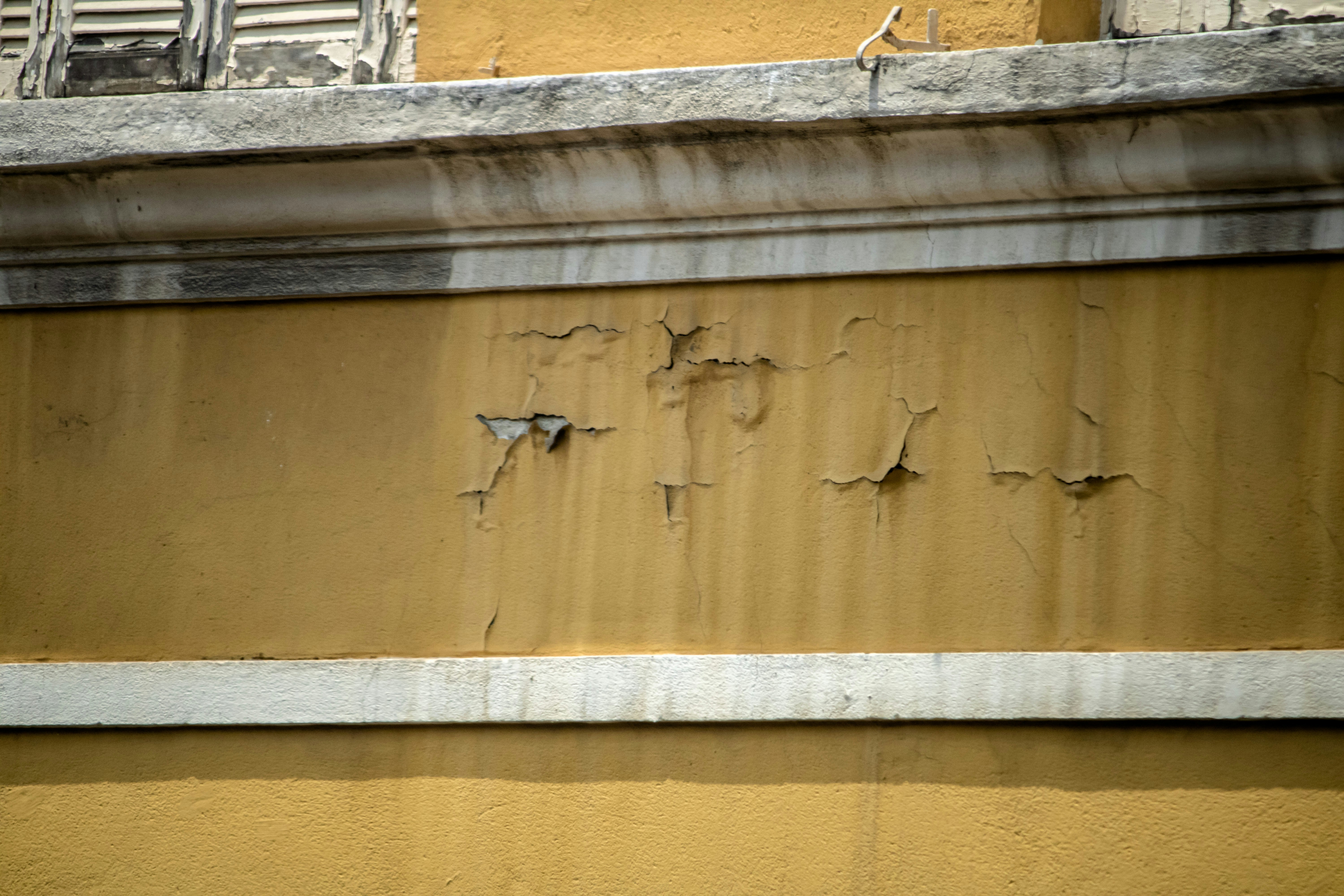 Weathered Yellow Facade with Peeling Plaster