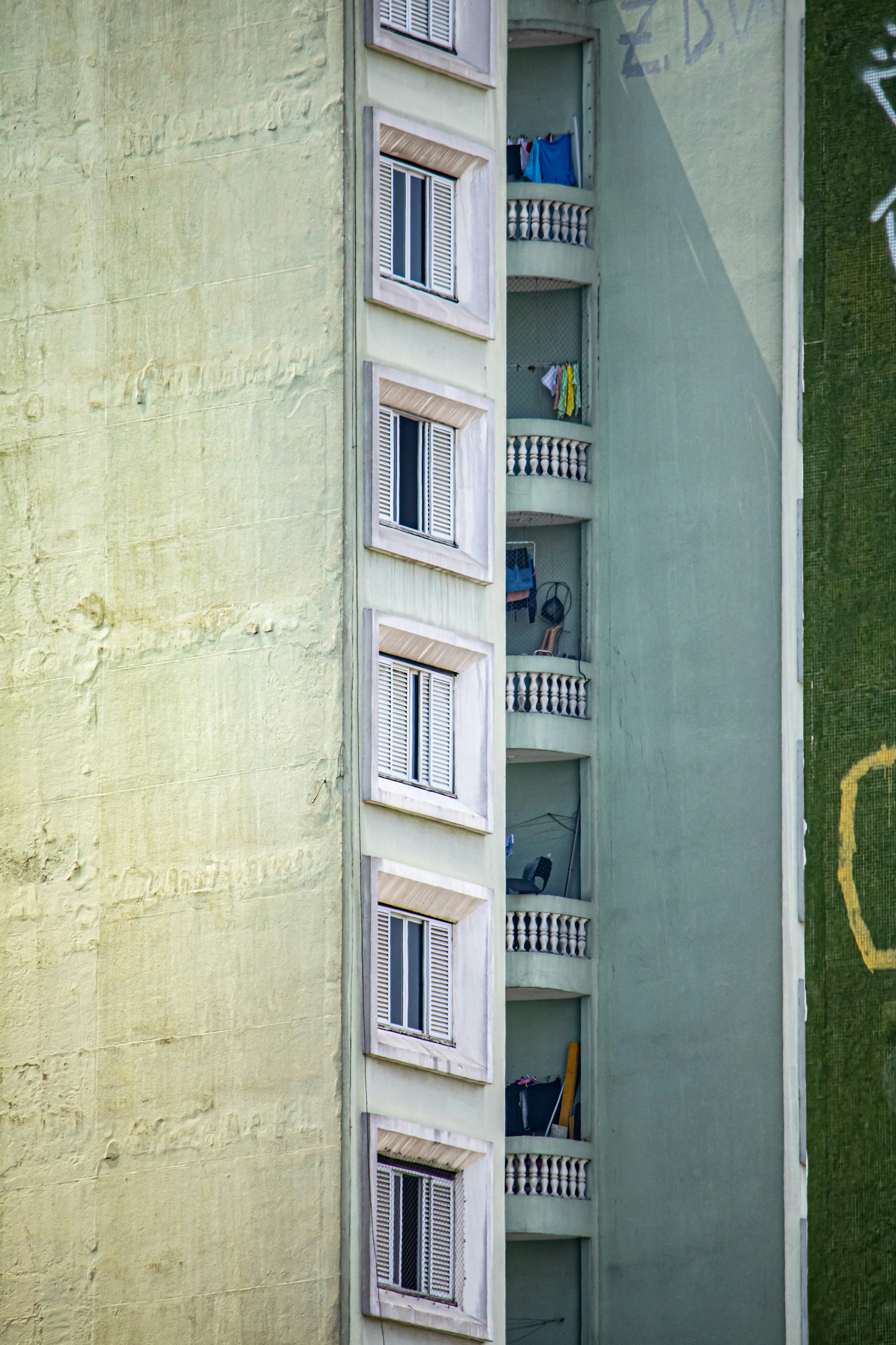 Vertical spine of pastel flats: balconies stacked along a sunlit facade