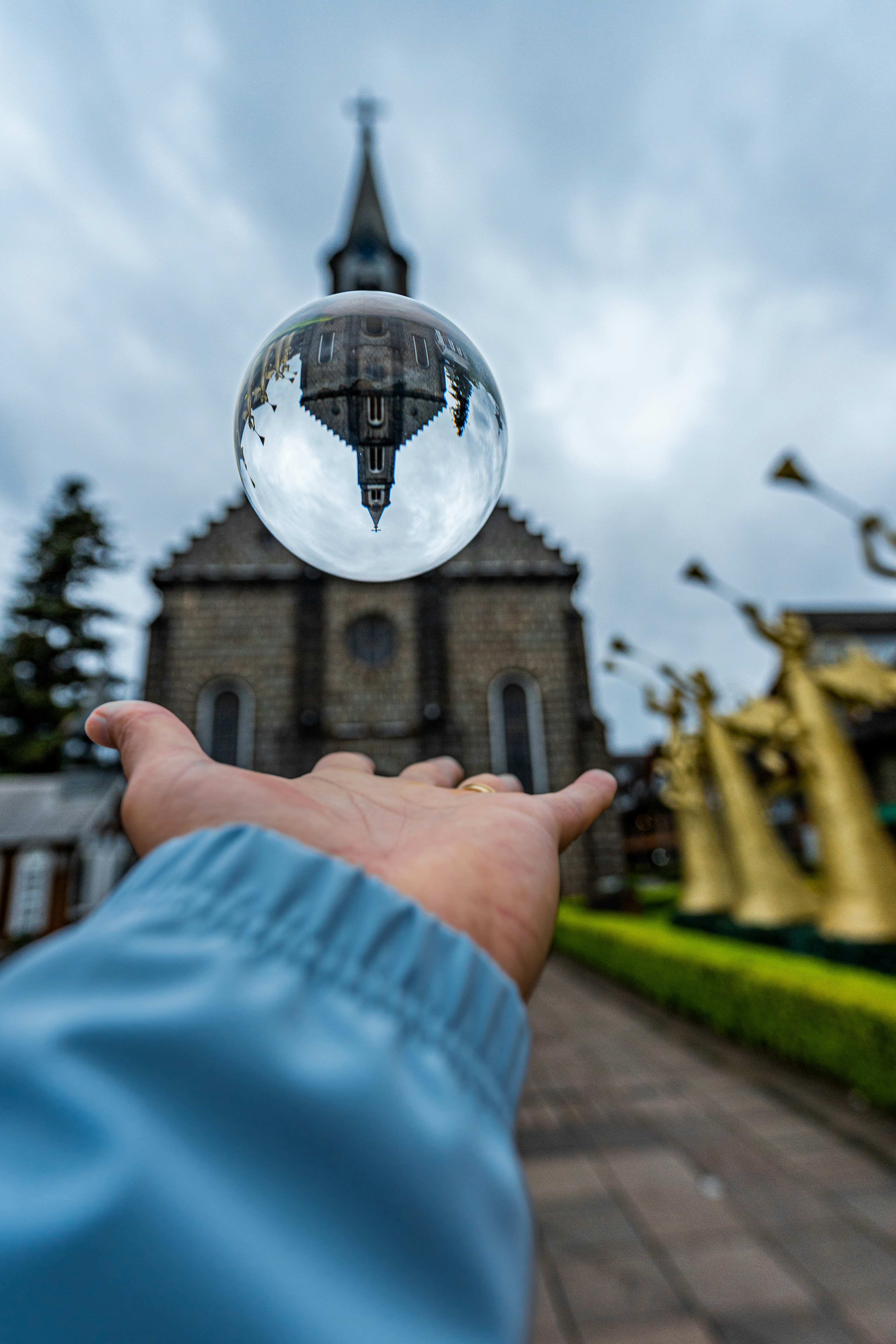 Reflected Spire: A Handheld Glass Globe Framing a Church