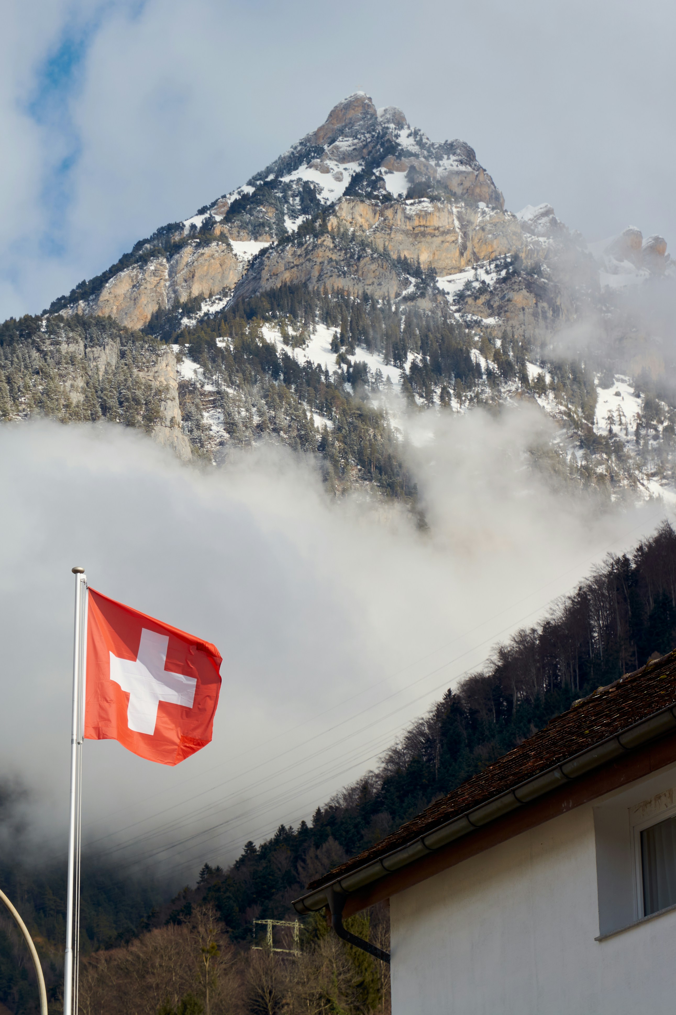 Switzerland, Fluelen. Mountains covered with snow and clouds on the shores of Lake Lucerne in Switzerland in winter.