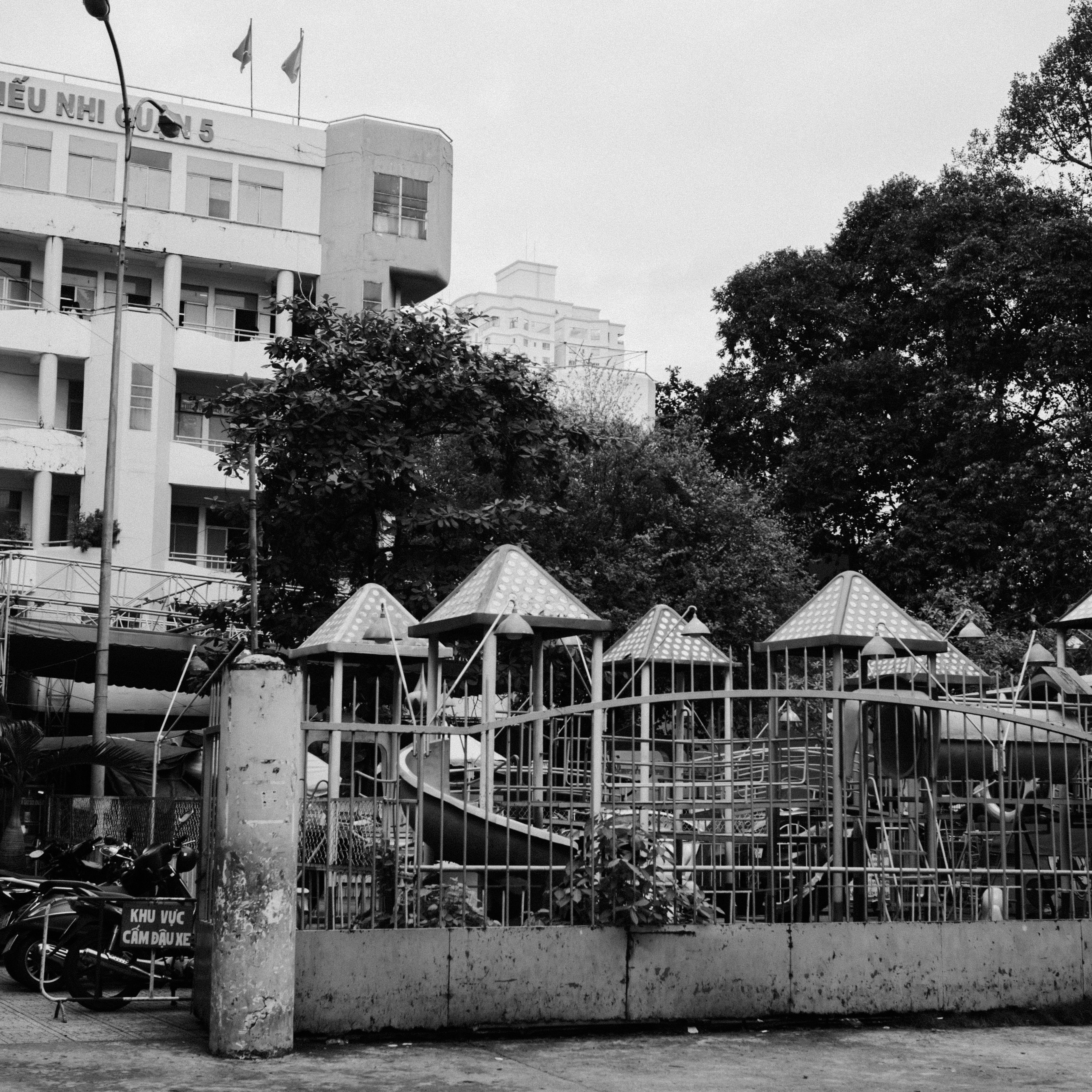 A black and white photo of a gated area with buildings in the ...