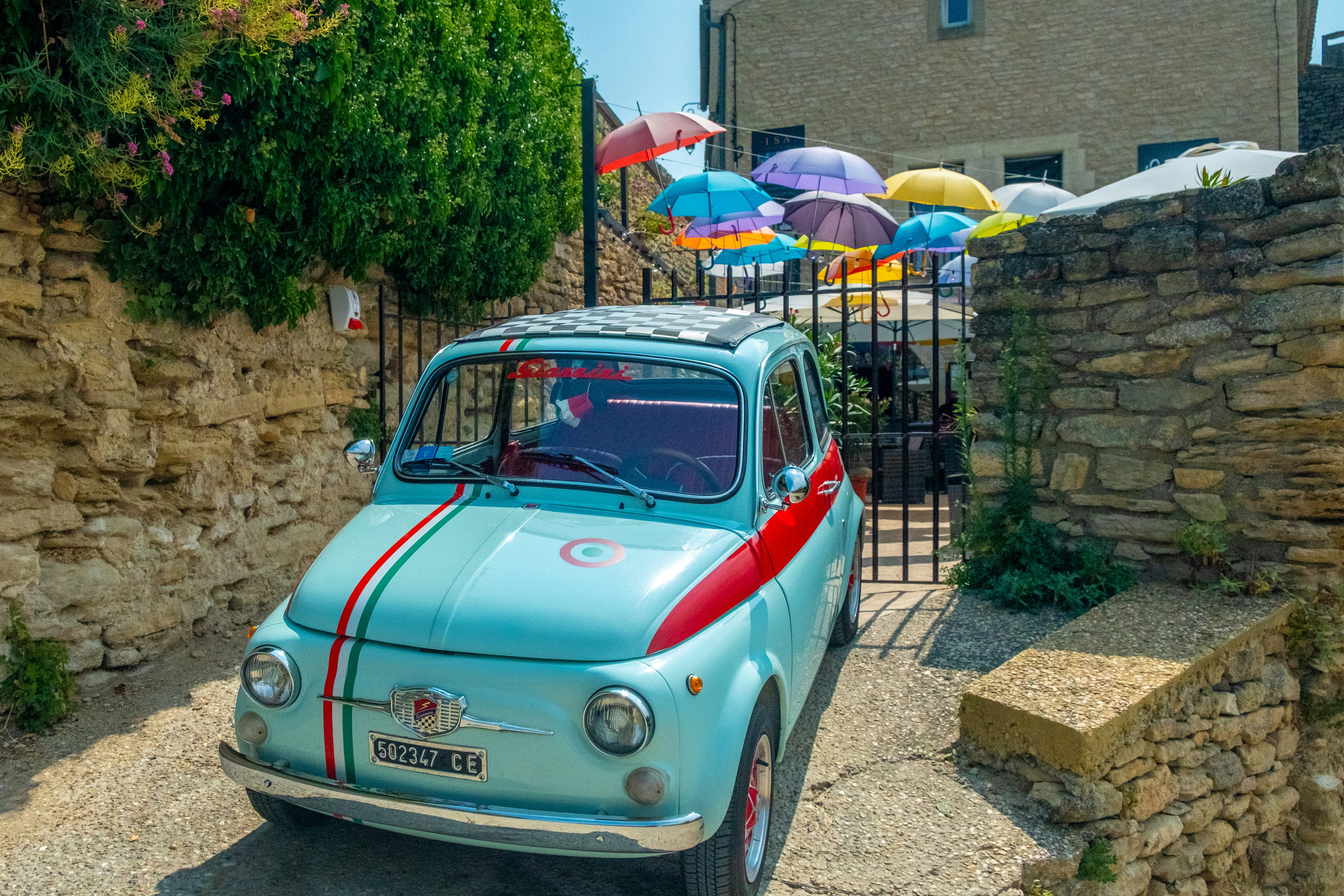 Pastel Fiat 500 Parade Under a Canopy of Rainbow Umbrellas