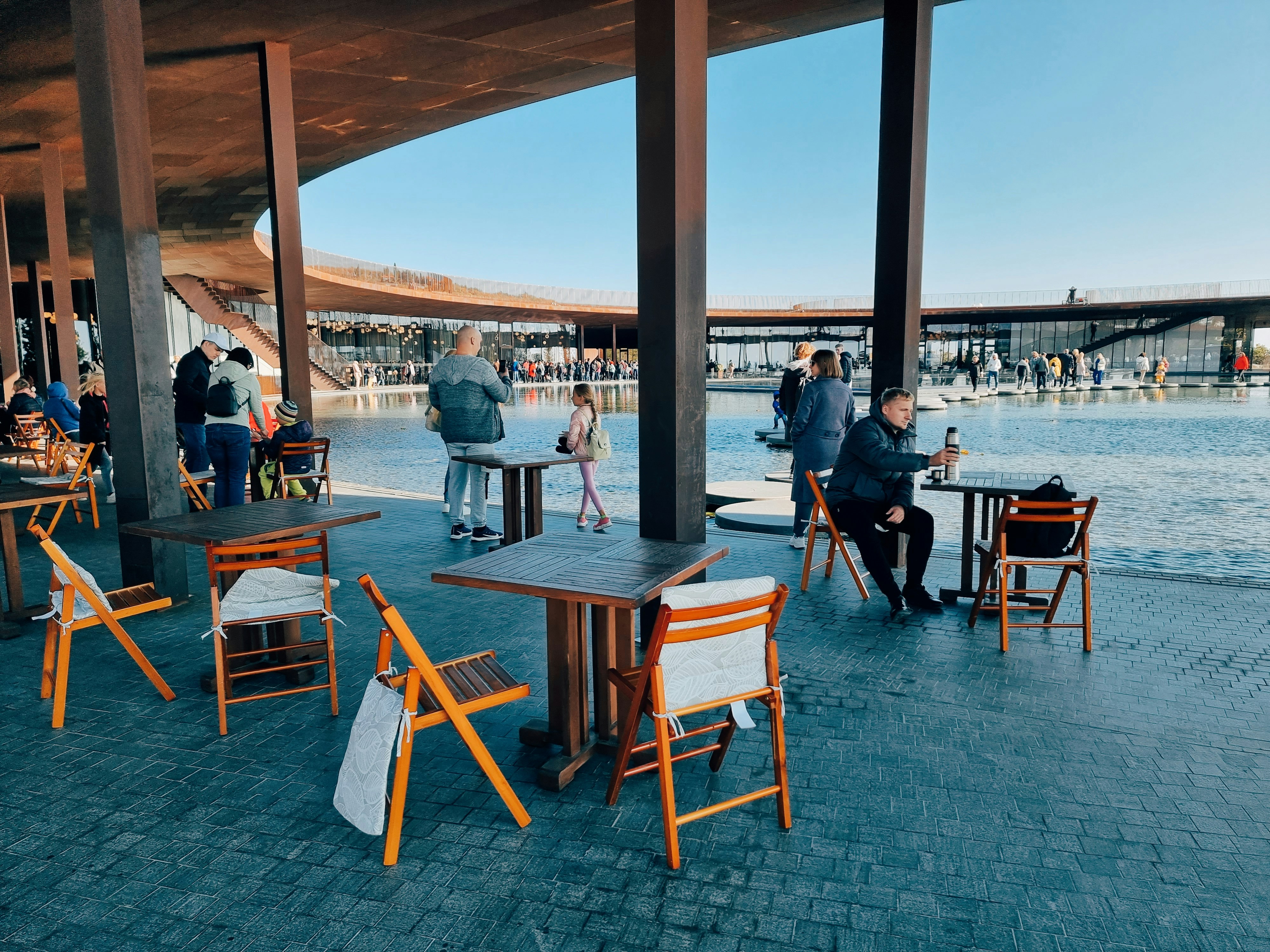 a group of people sitting at tables on a dock