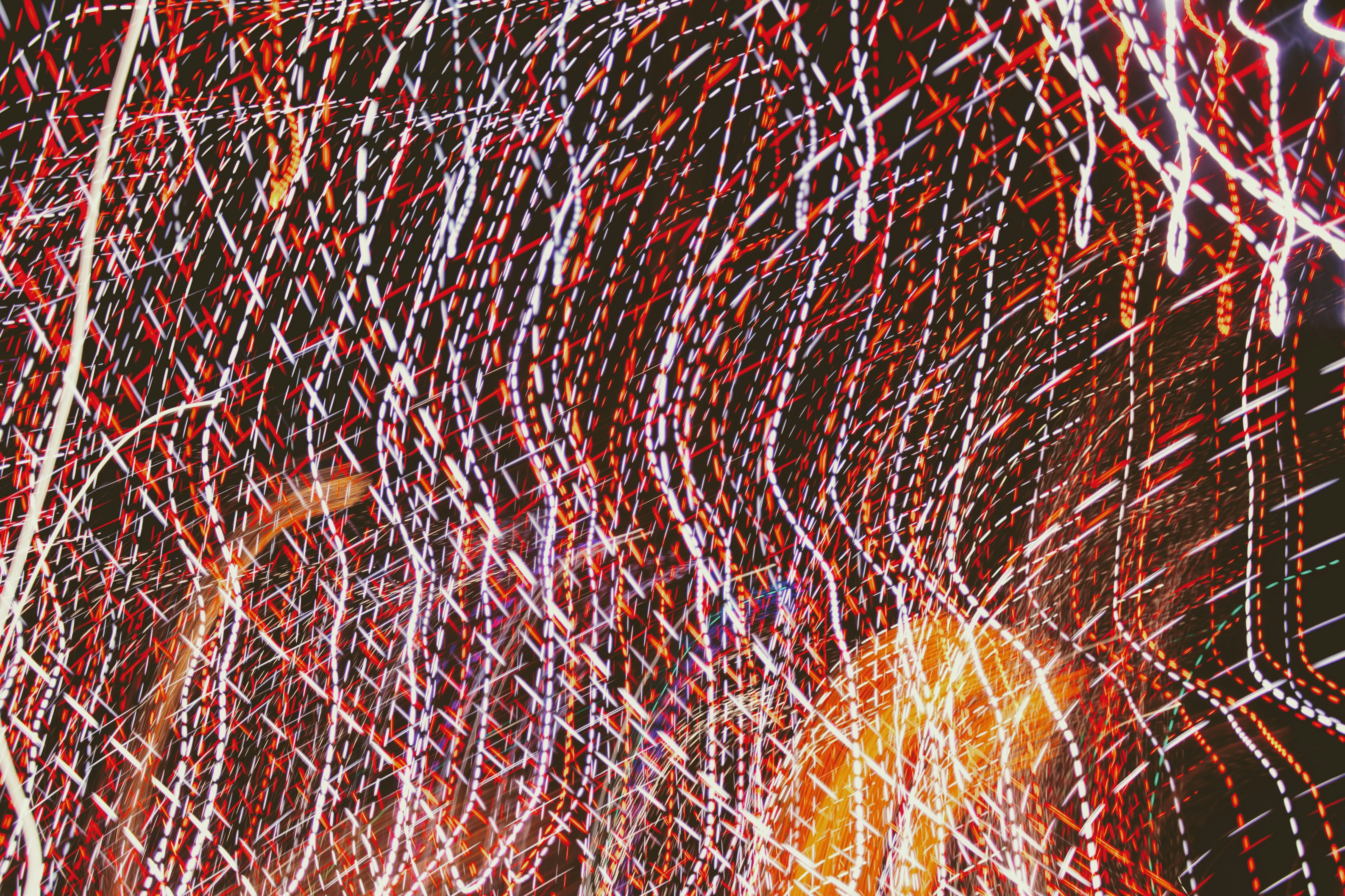 A vibrant display of swirling light trails against a dark background, creating a mesmerizing abstract pattern.