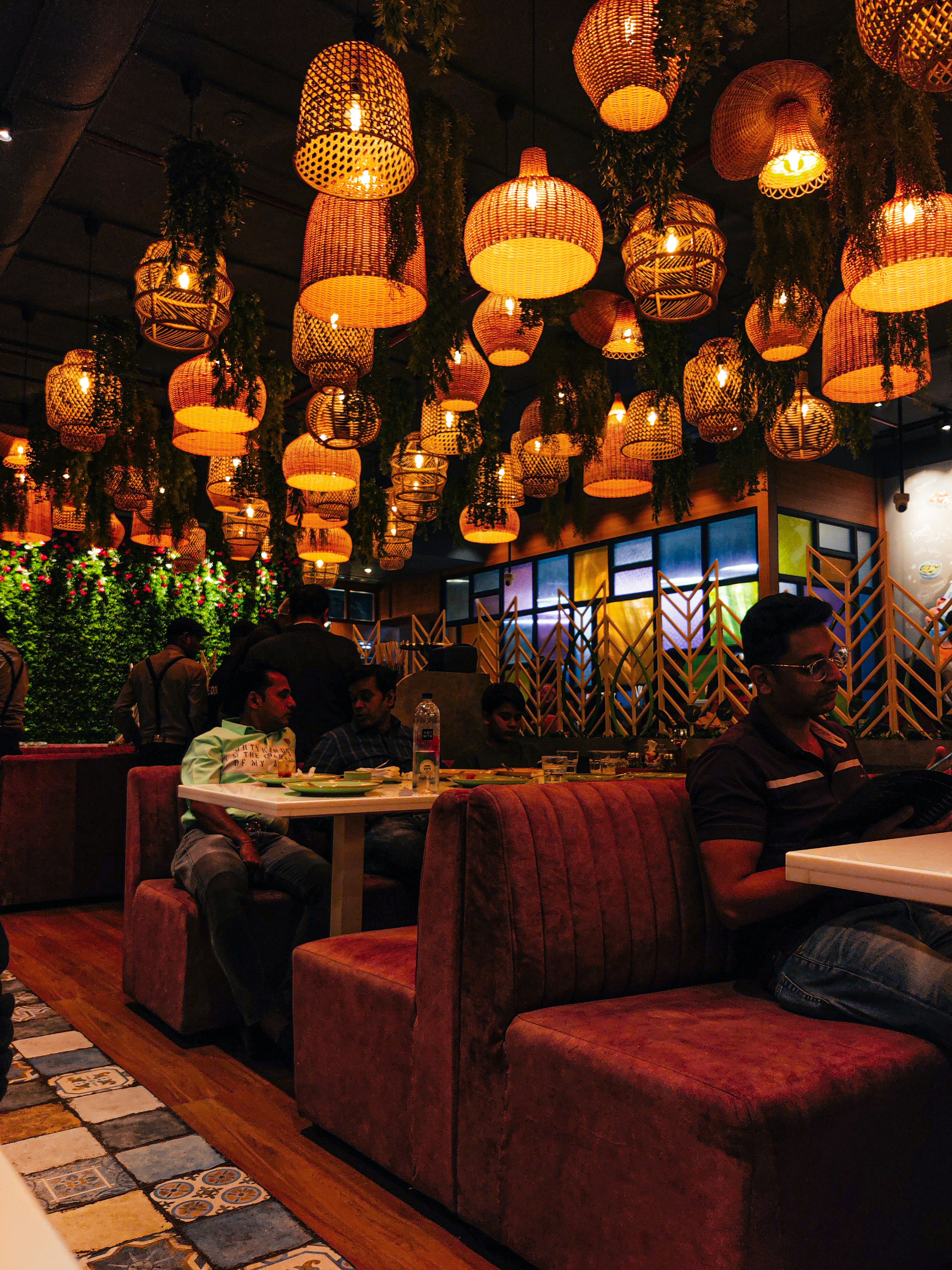 People sitting at tables under chandeliers photo – Free Phadke road ...