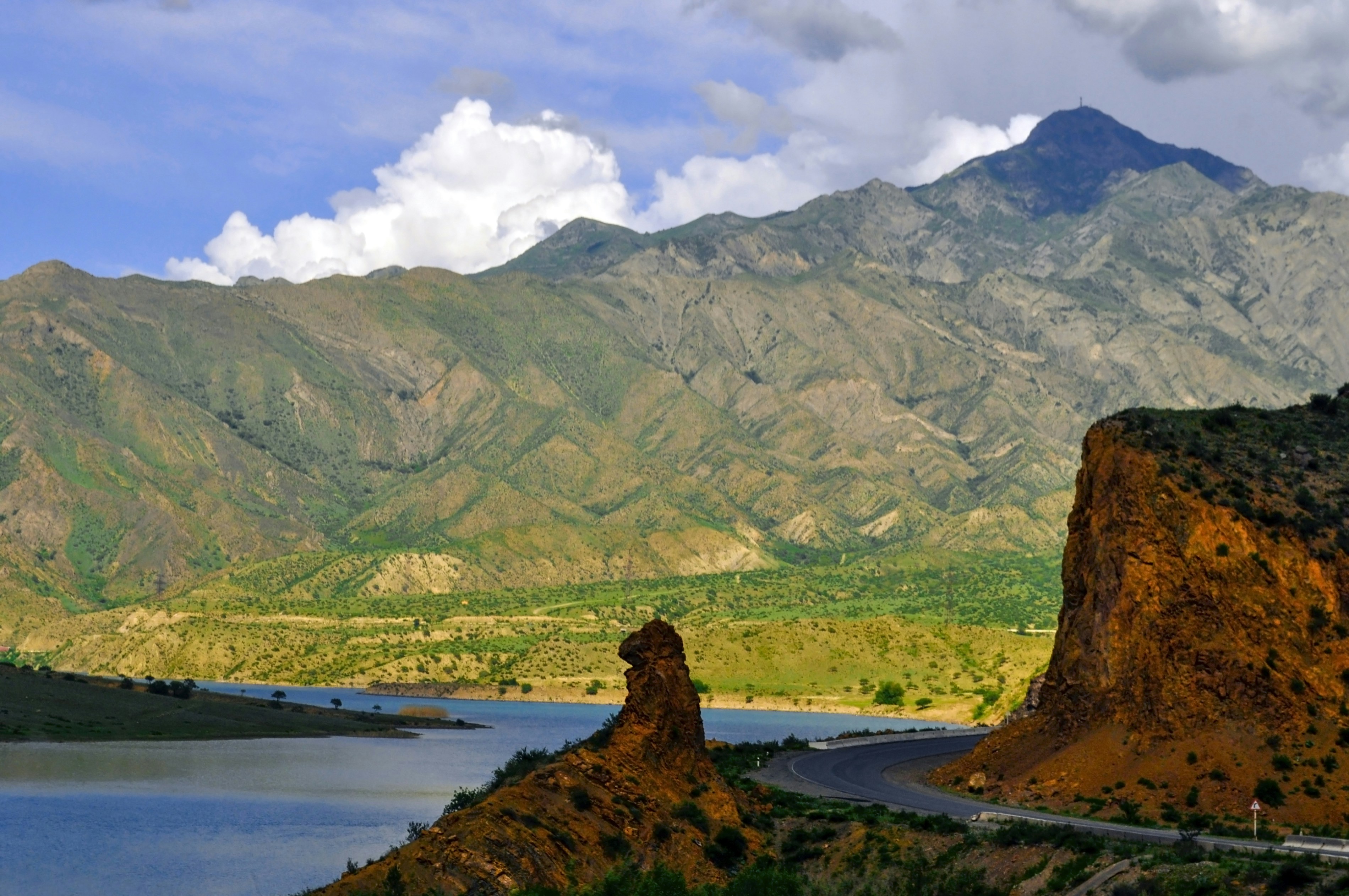Terracotta Sentinel by the Bend: A Desert Riverscape Beneath Rugged Peaks