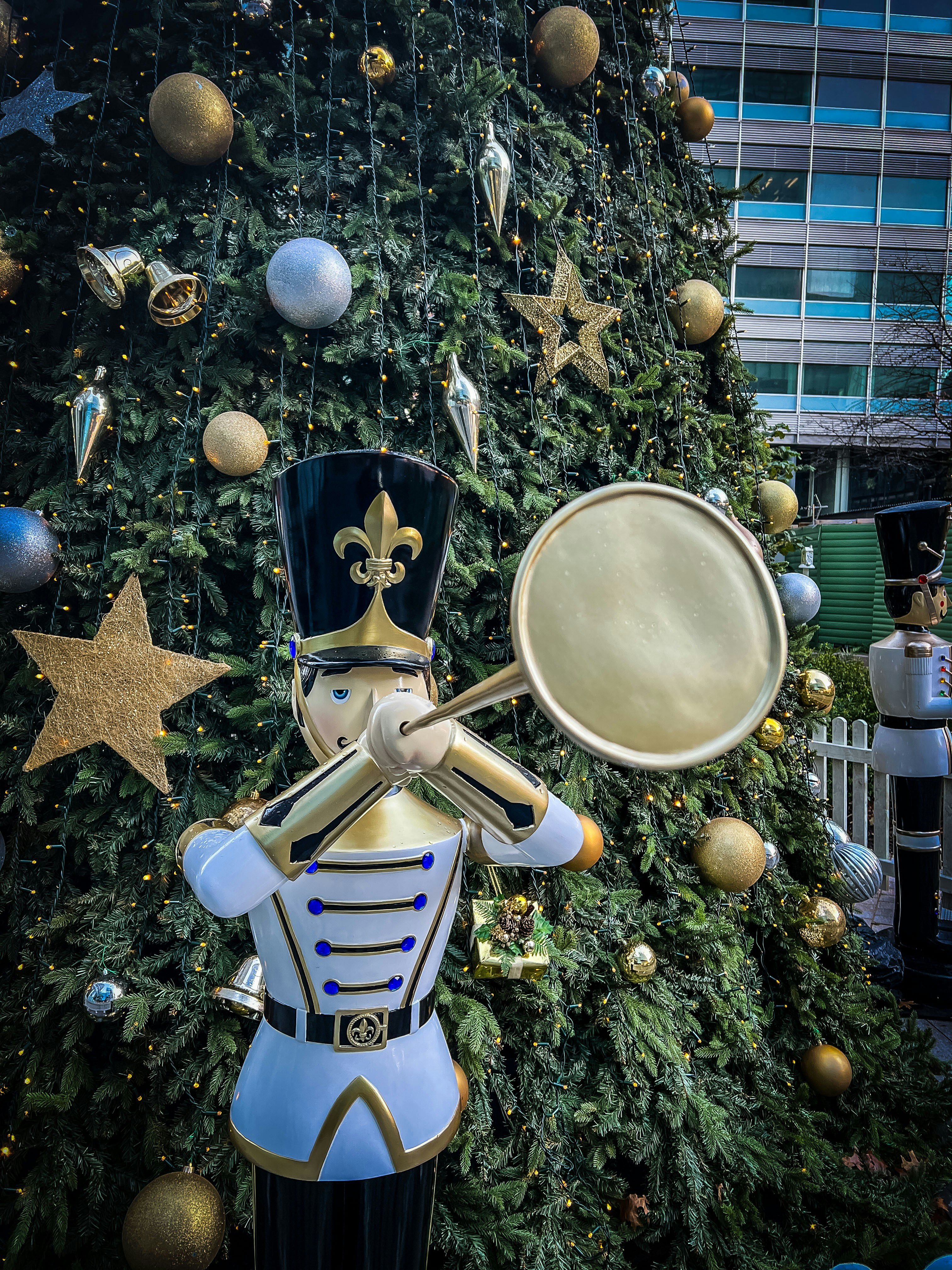 Trumpet-Wielding Nutcracker Framed by a Glittering Christmas Tree