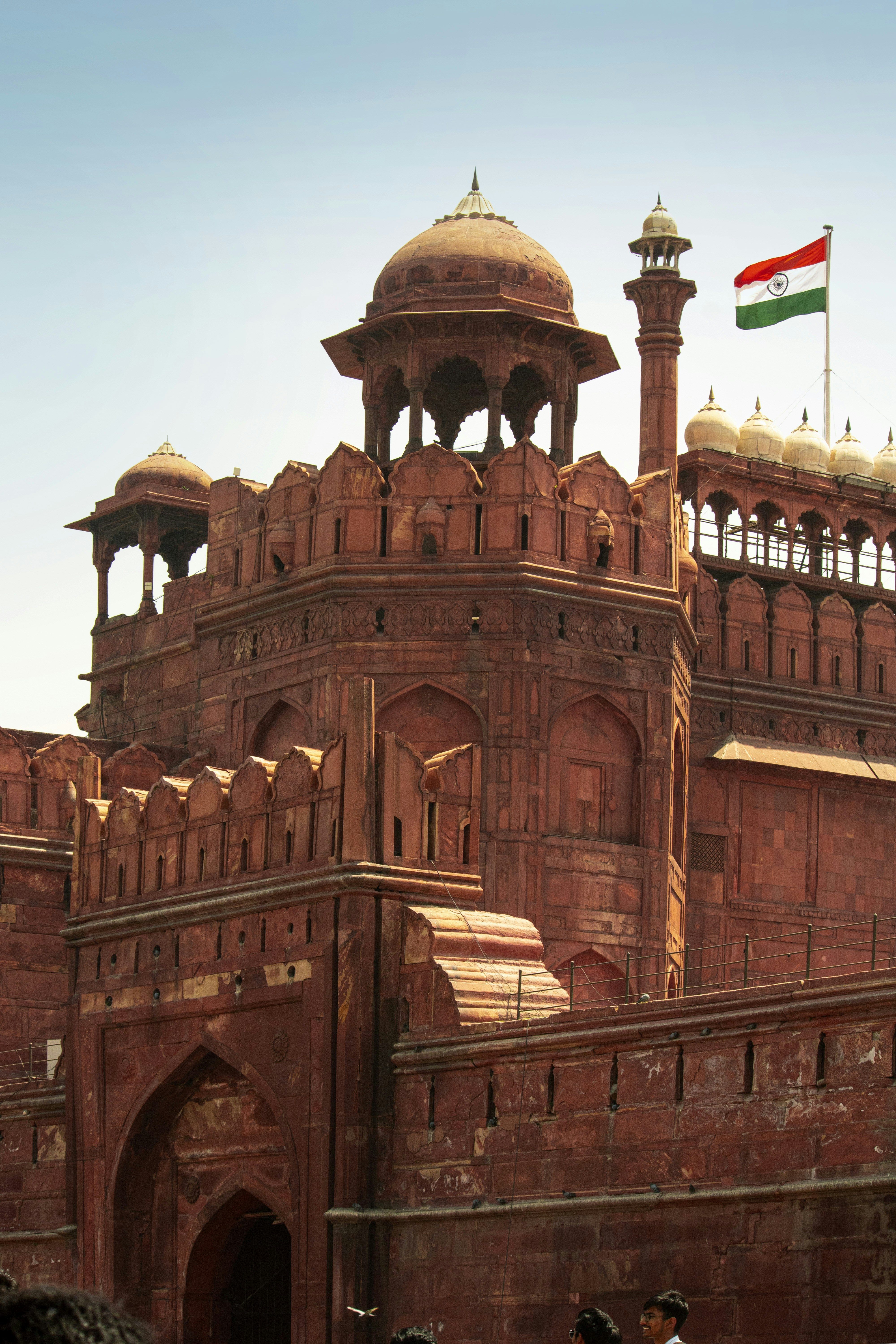A large building with a flag on top with Red Fort in the background ...