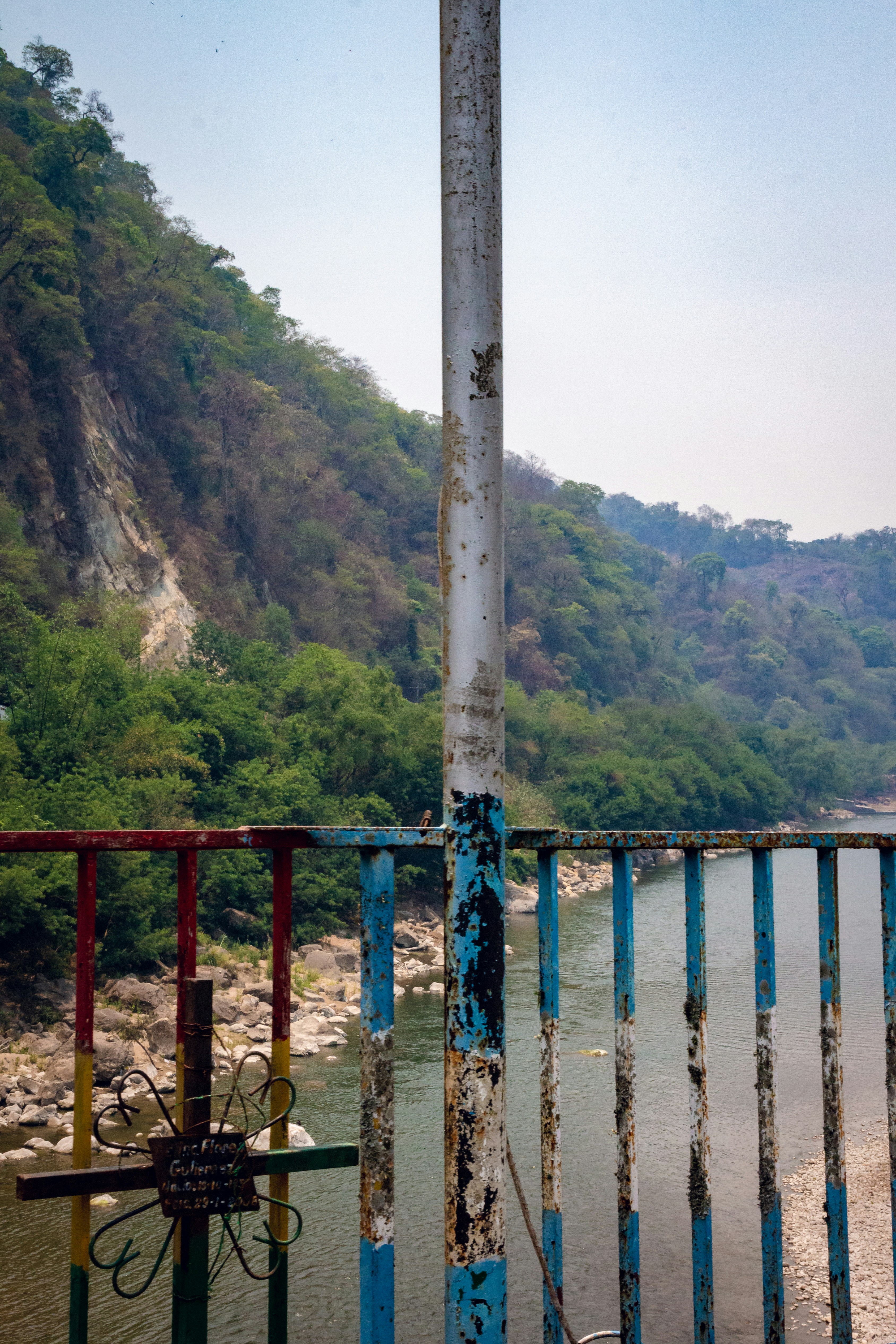 Rust and Blue Rails Framing a Verdant River Gorge