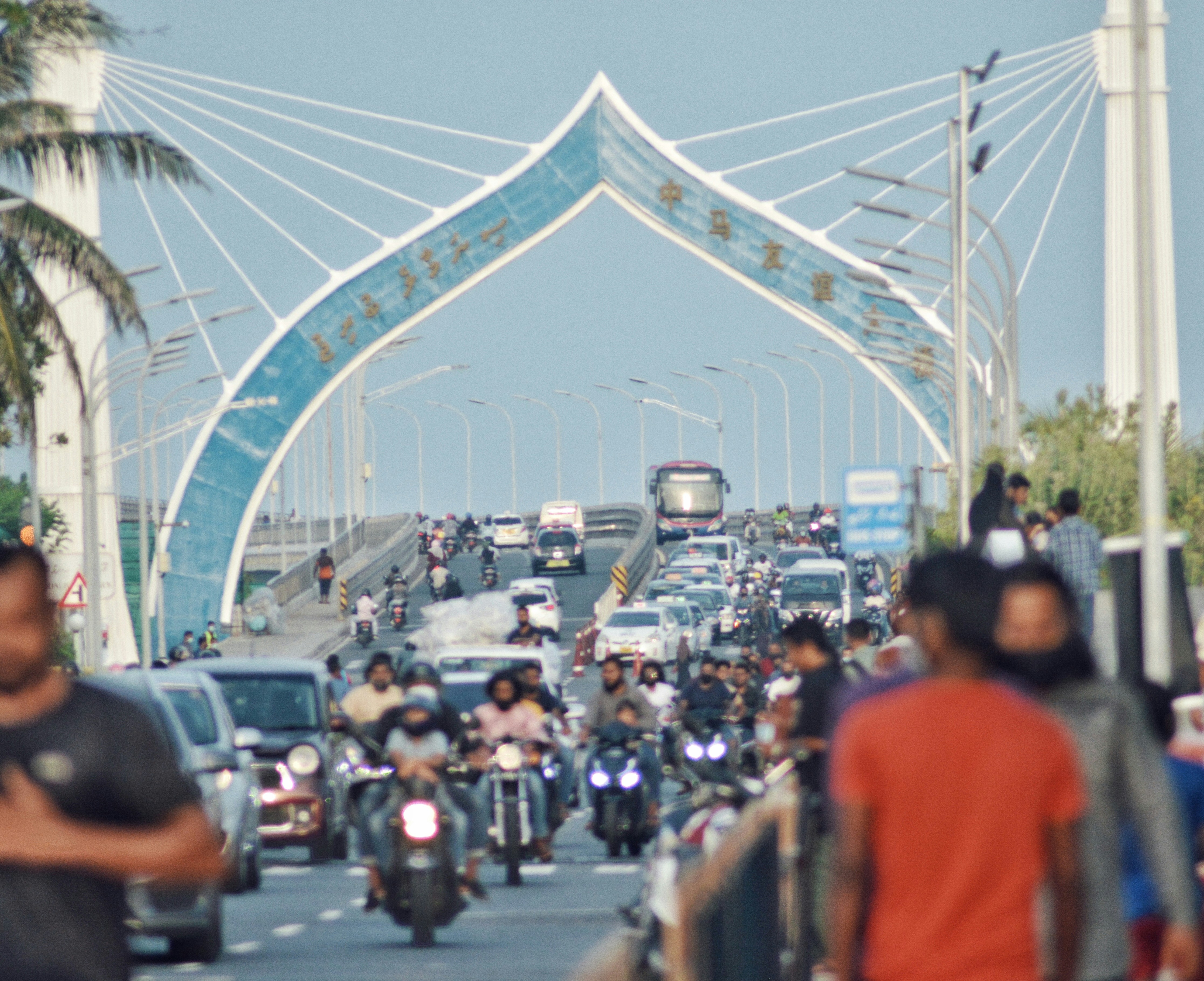Archway of the Bridge: Crowds and Motorbikes on a Distant Pier
